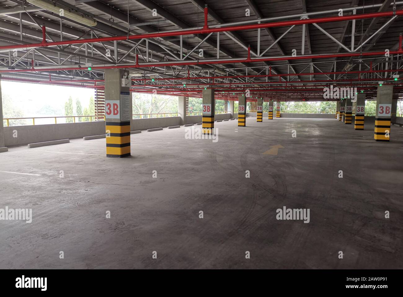 Empty car park building with metal pipe and red fire water pipe on ...