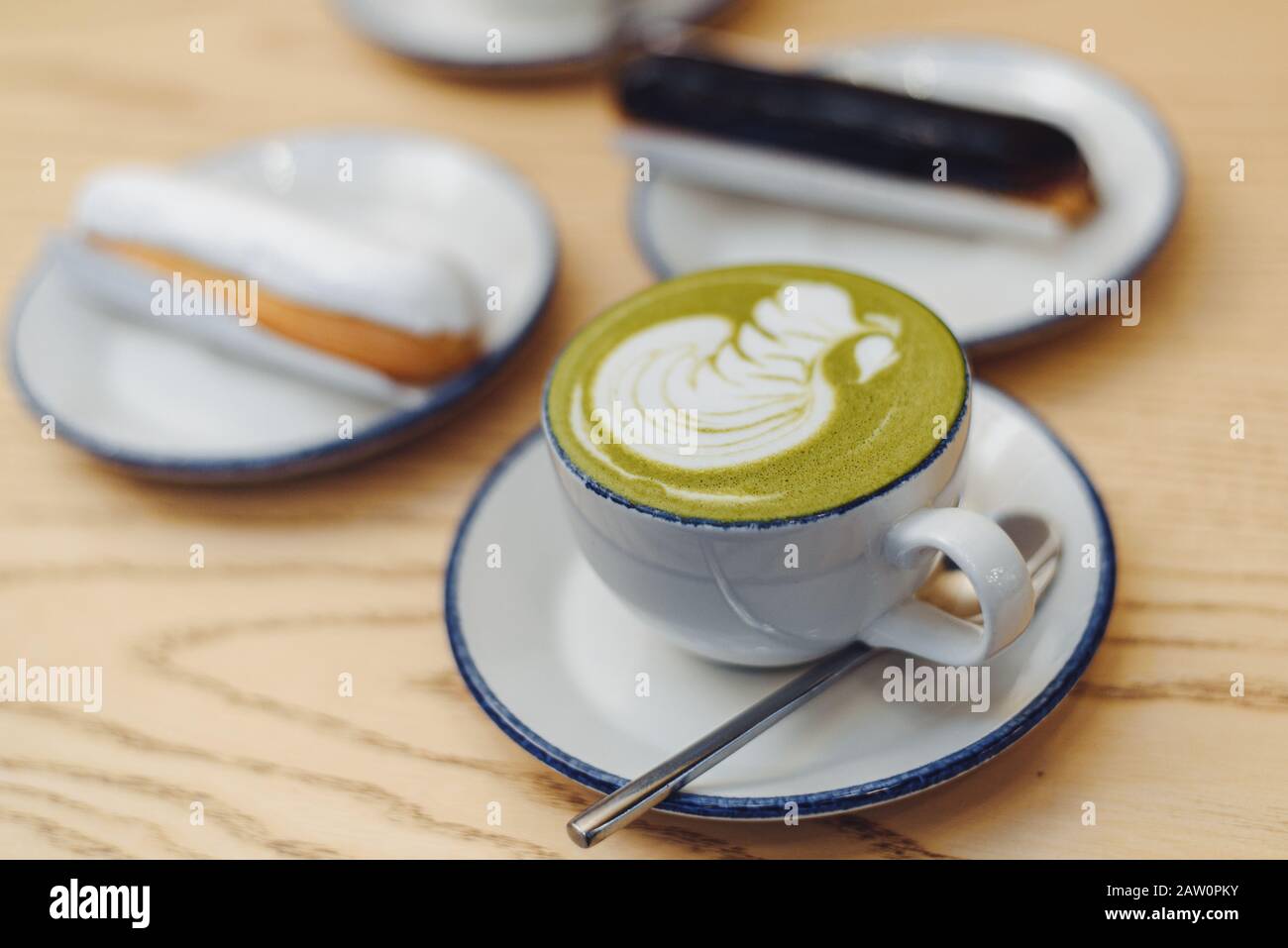 Green matcha with a eclair. Cozy coffee shop Stock Photo - Alamy
