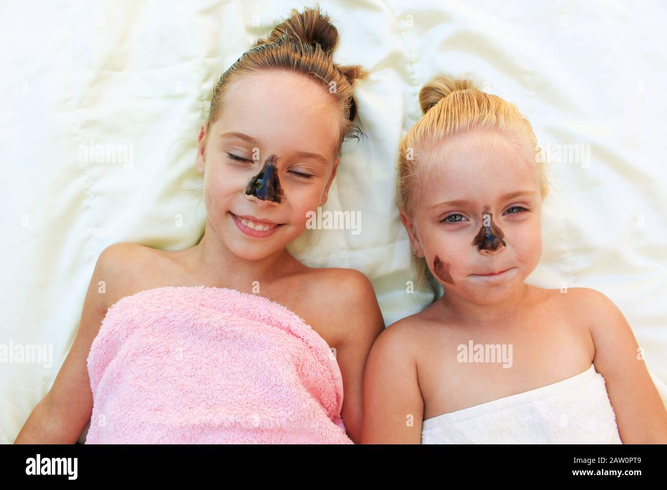 Beautiful girls with facial black clay mask Stock Photo - Alamy