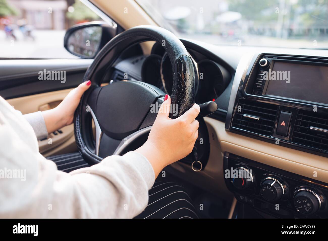 Asian female hands on the steering wheel of a car while driving with ...