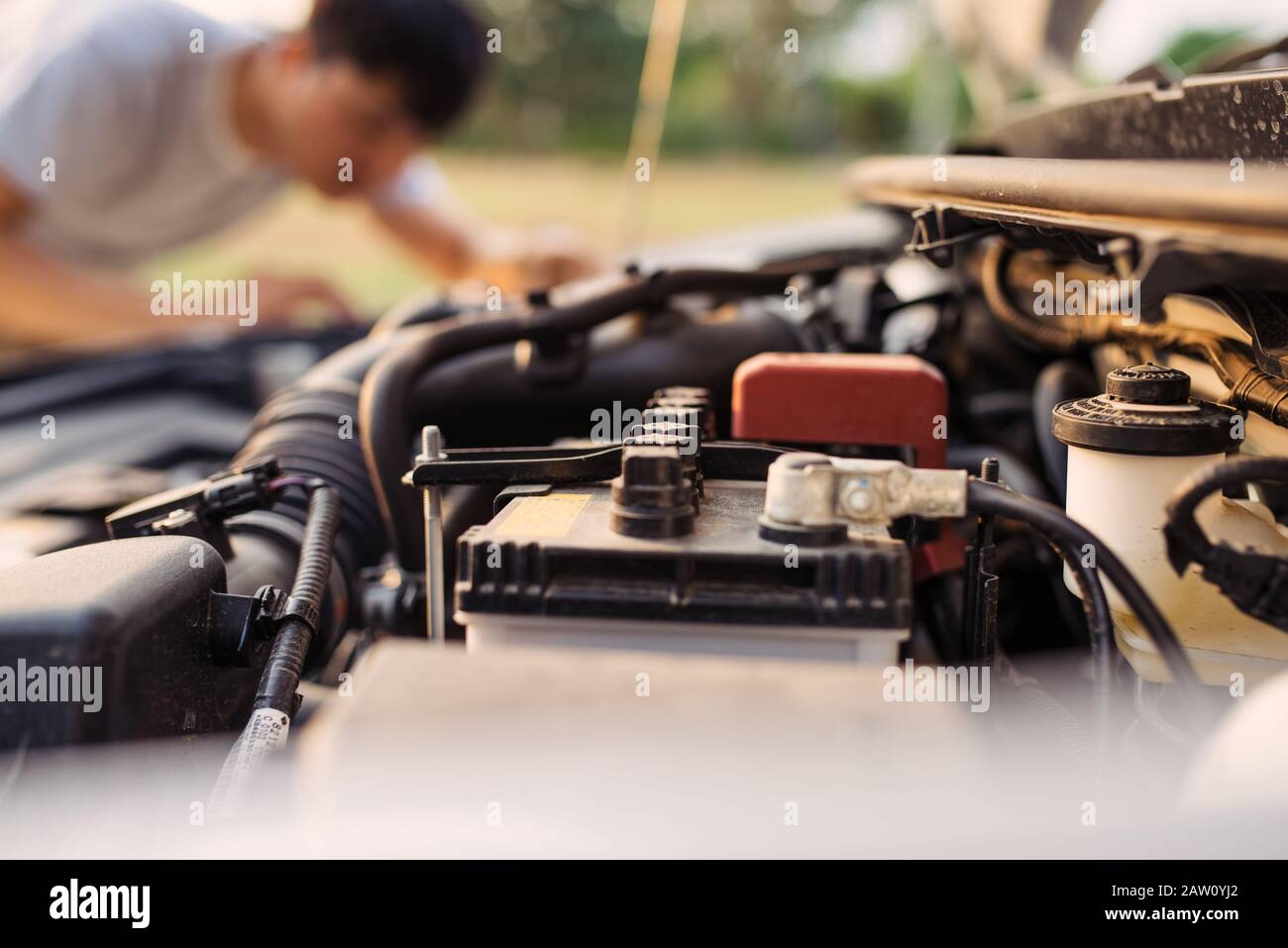 A man tries to repair the car on the road Stock Photo - Alamy