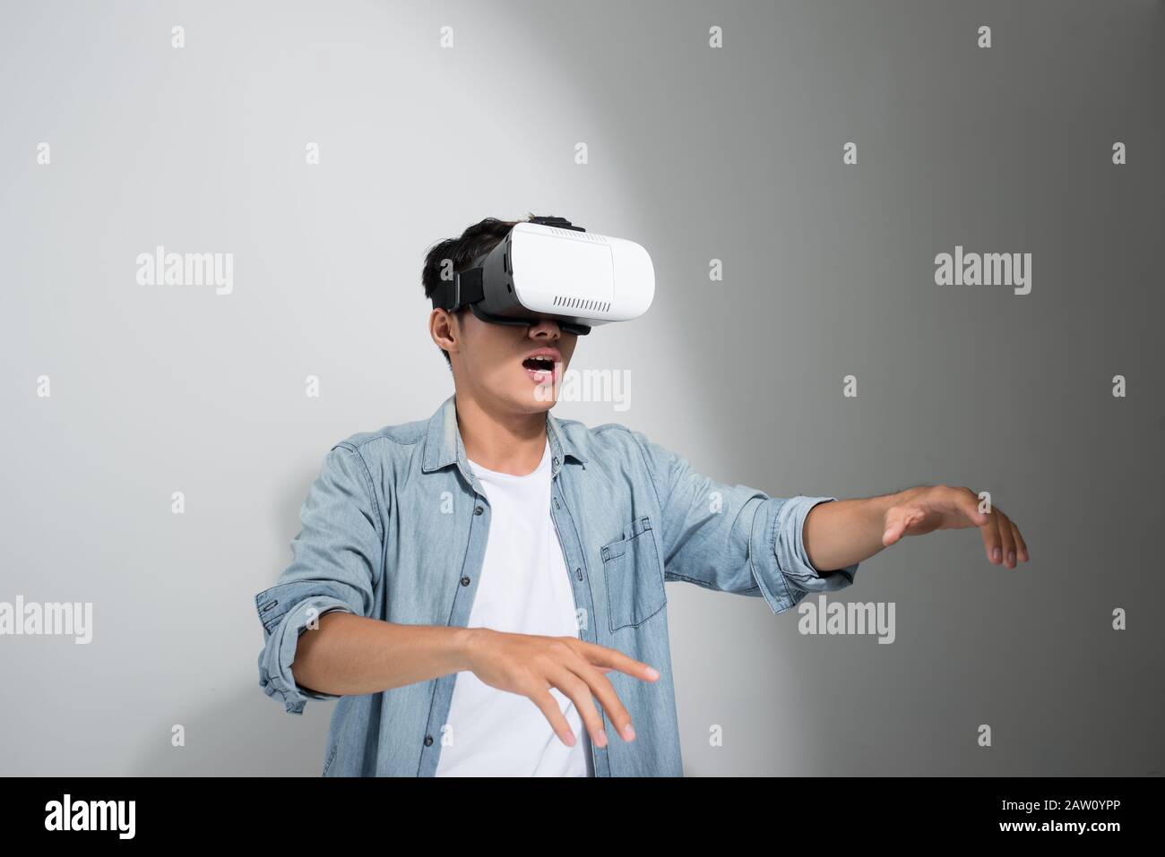Excited man experiencing virtual reality via VR headset and touching ...