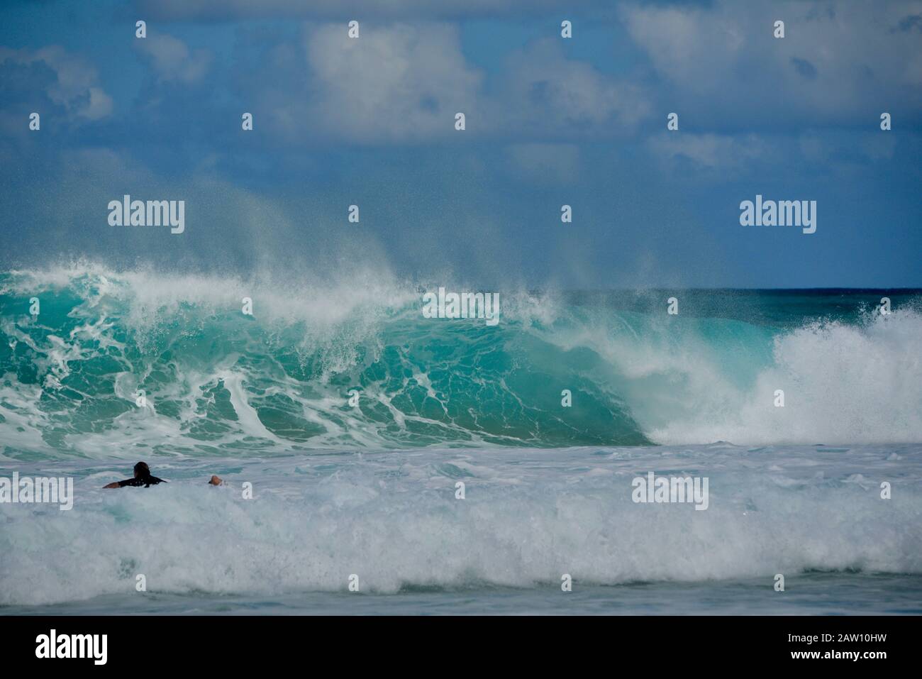 Surfer paddling out to world-renowned crashing, barreling curved ...