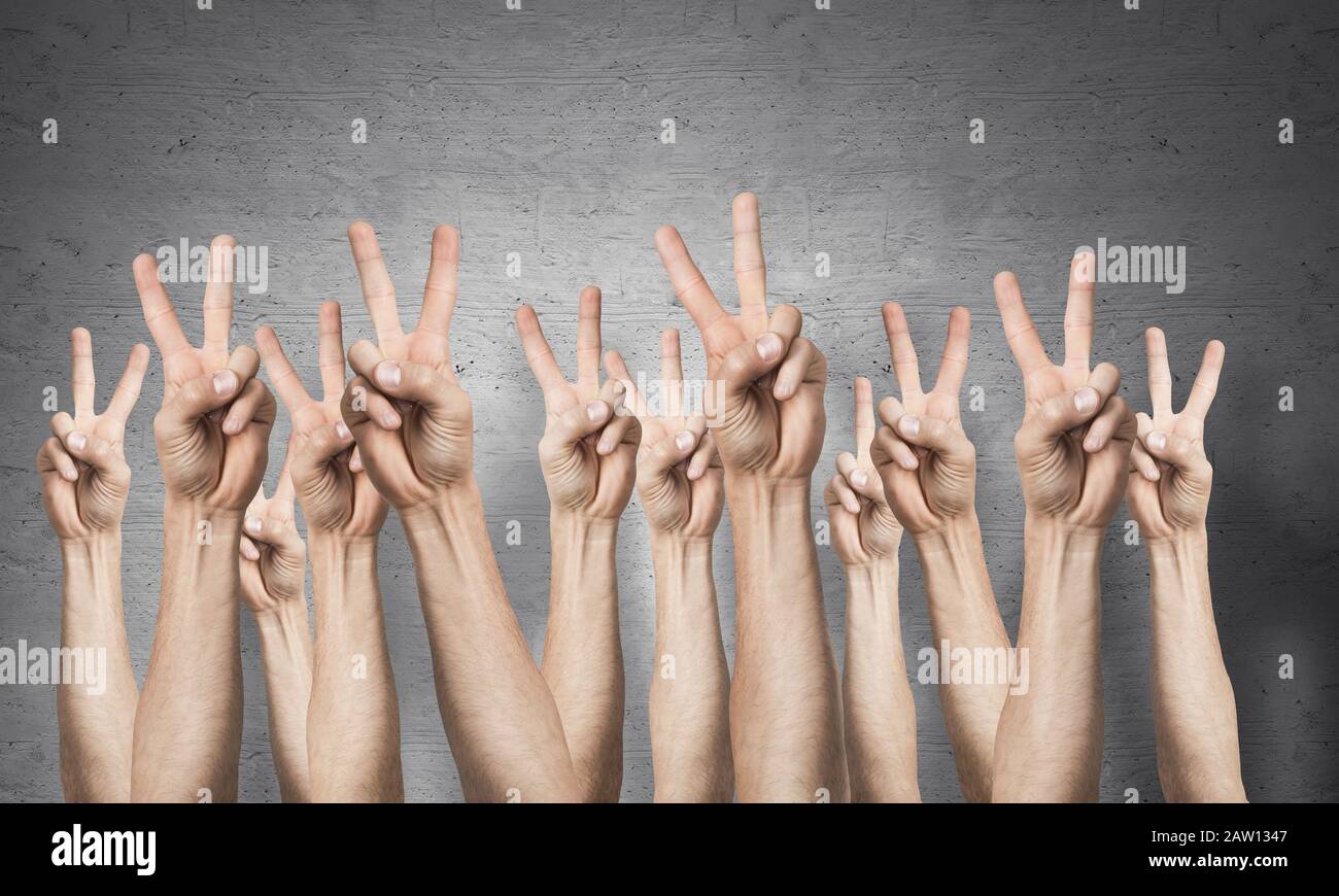 Row of man hands showing victory gesture Stock Photo - Alamy