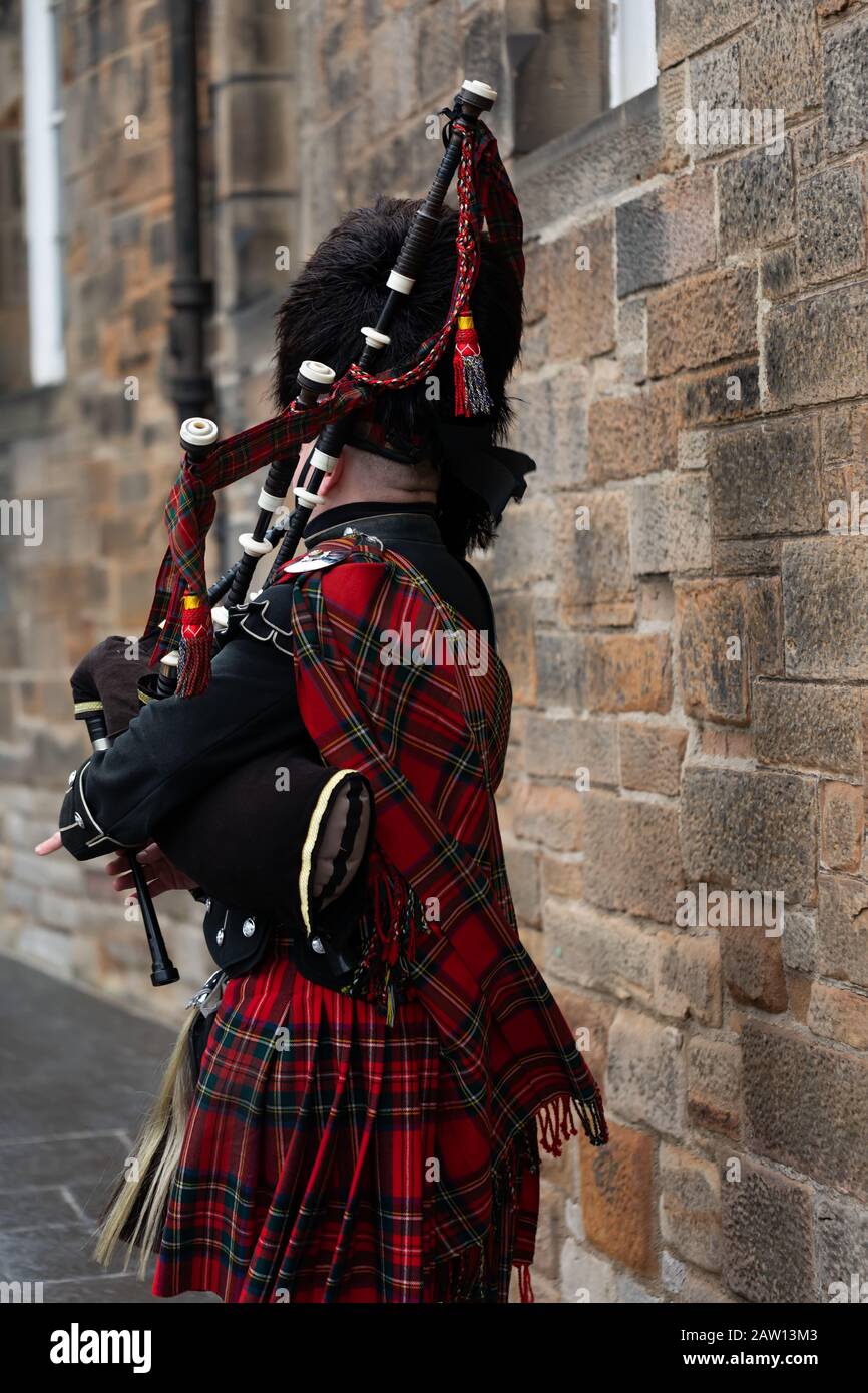 Scottish piper playing the bagpipes in traditional costume in Edinburgh ...