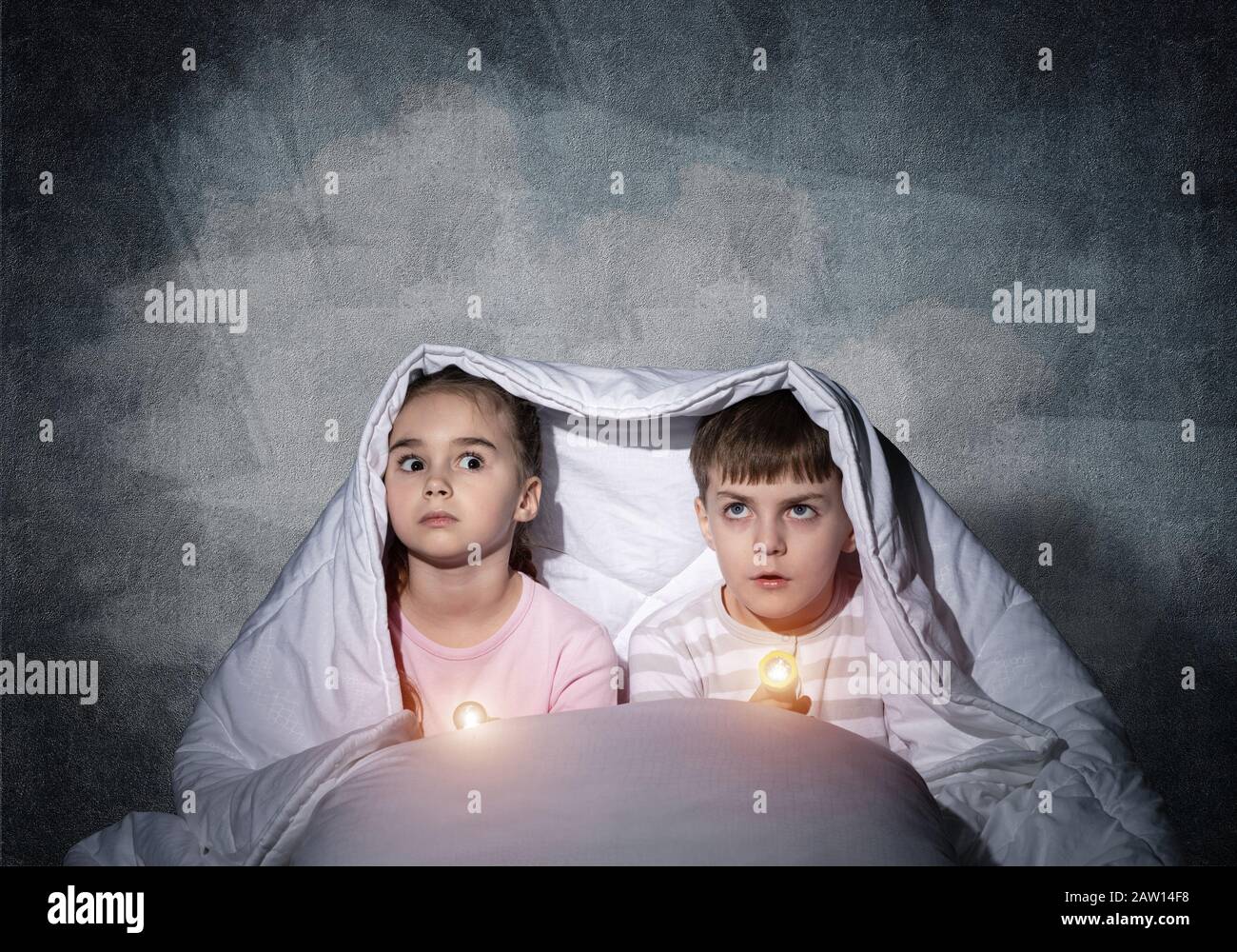 Scared children with flashlights in bed Stock Photo - Alamy