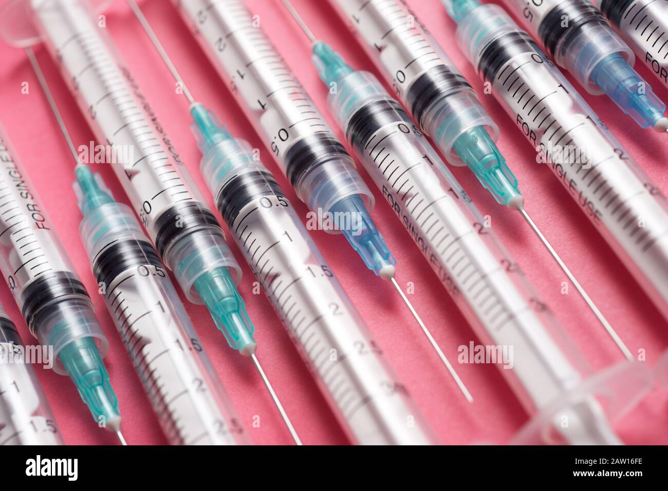 Close-up of a group of syringes on a pink table Stock Photo - Alamy