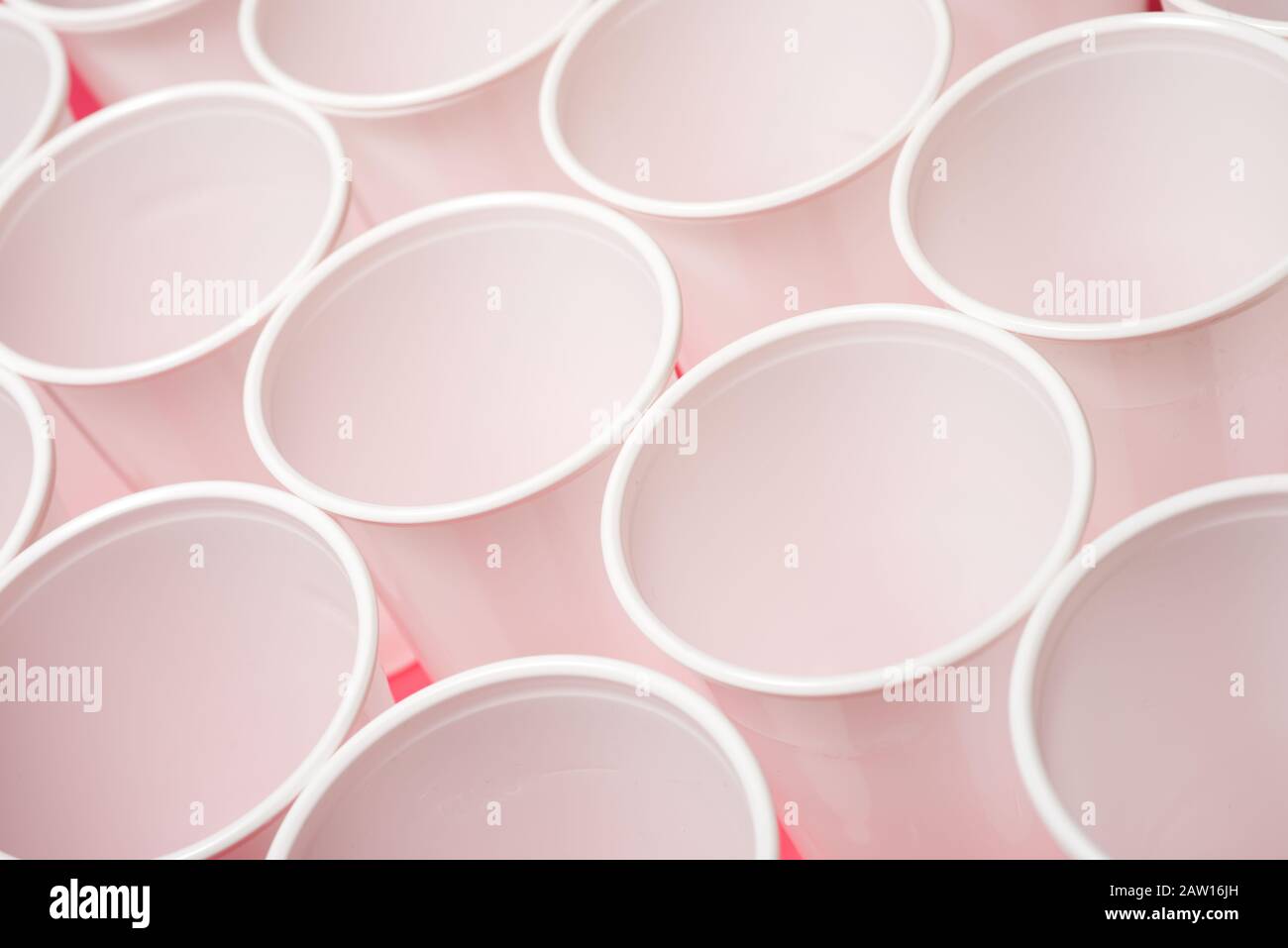 Large group of disposable plastic cups on a pink table Stock Photo - Alamy