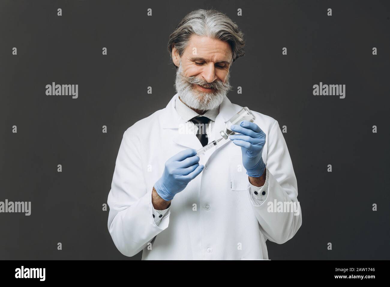 Doctor with syringe is preparing for injection. Old male doctor in ...