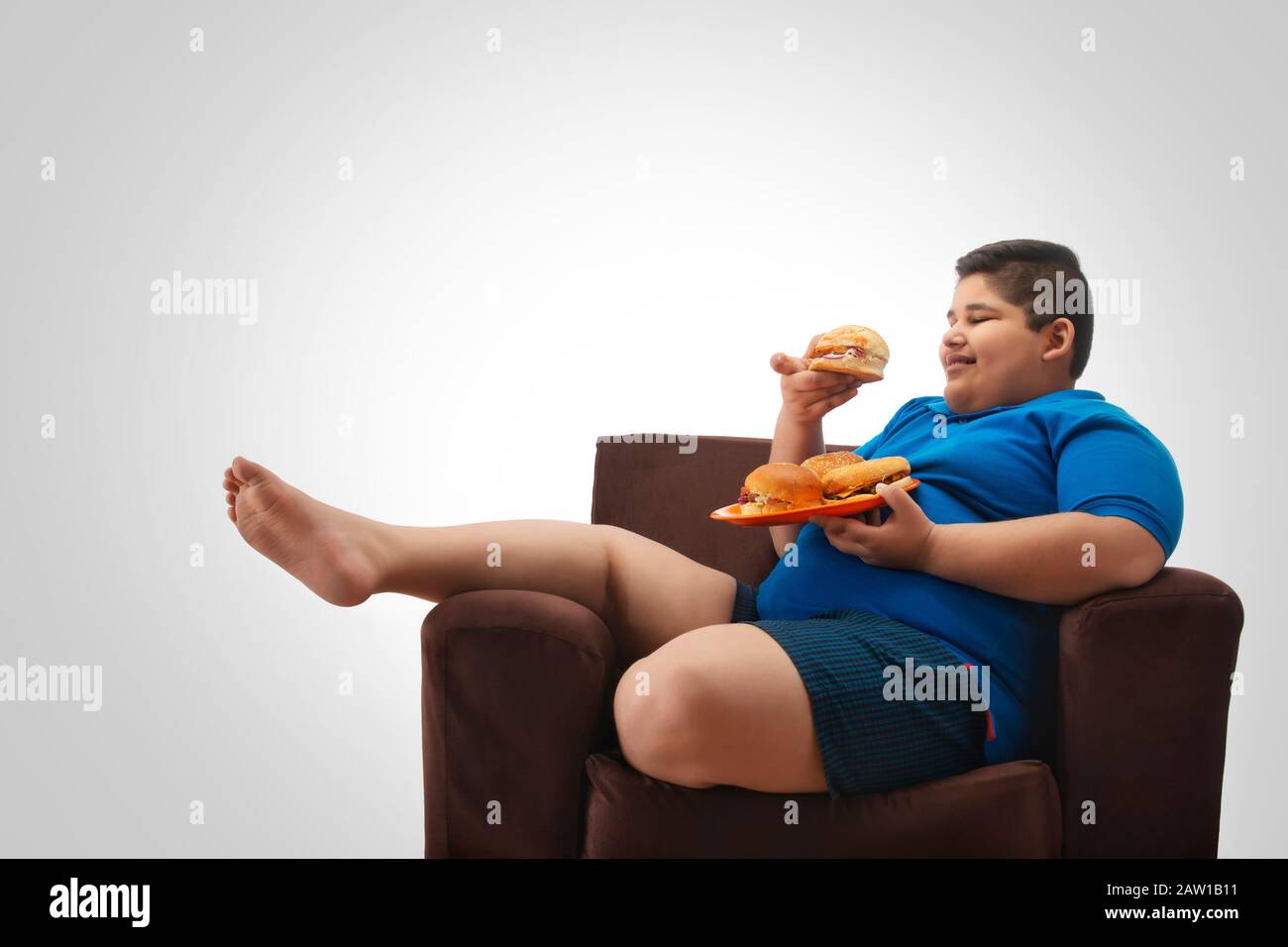 Overweight children on the sofa hi-res stock photography and images - Alamy