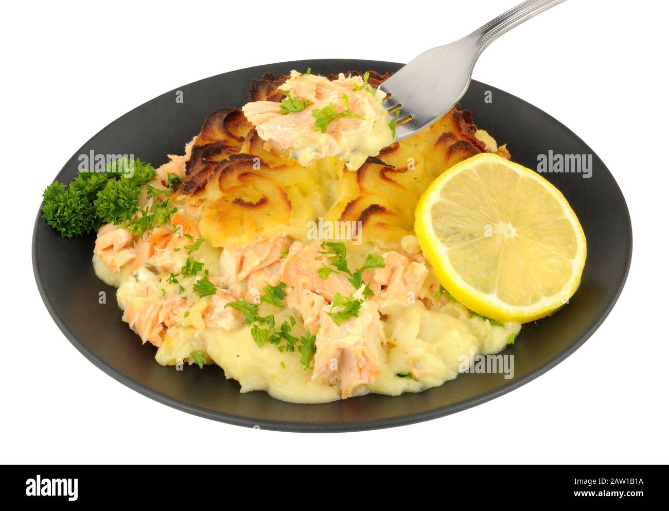 Portion of crispy potato topped fish pie on a black plate isolated on a ...