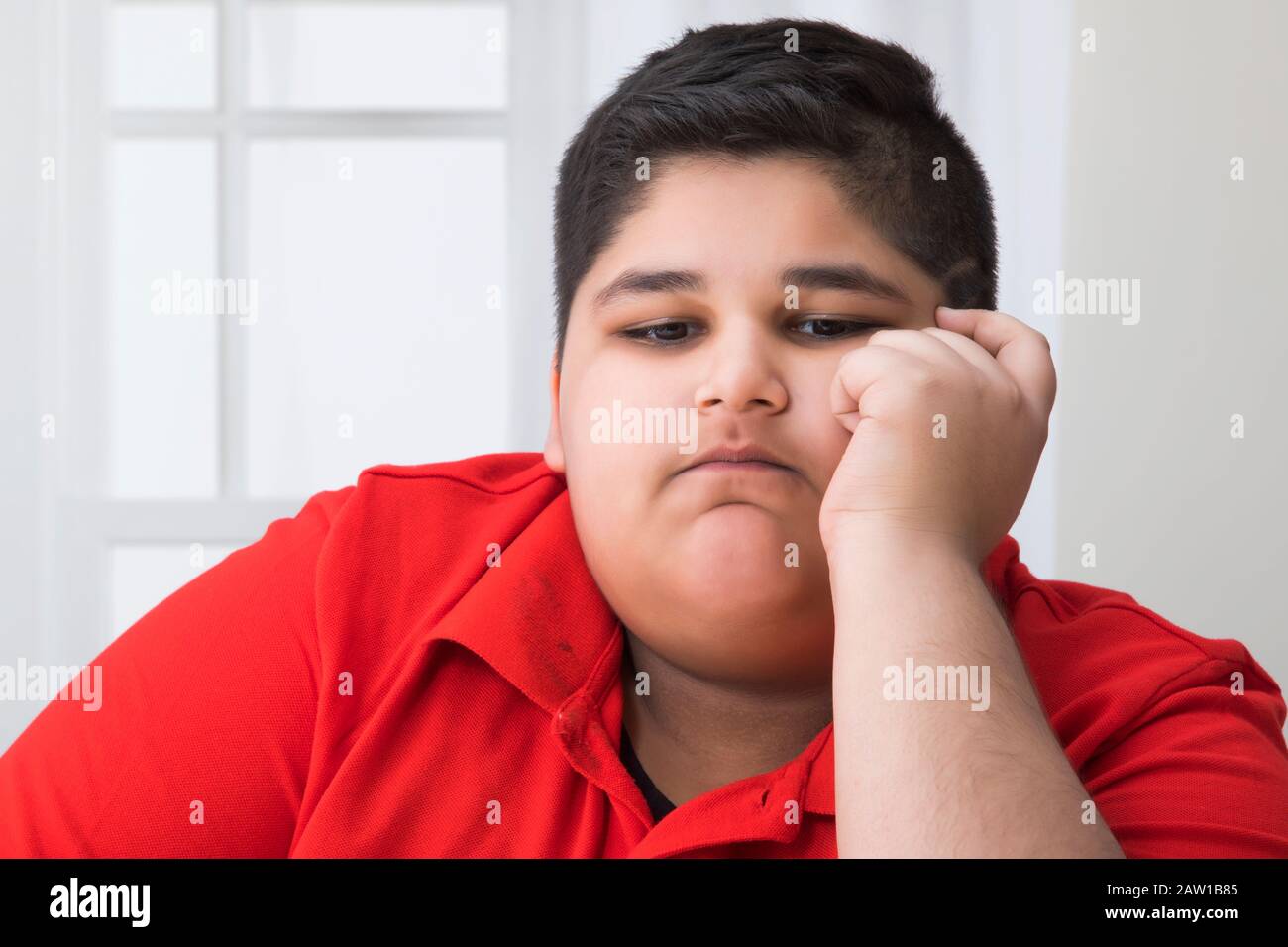 Young boy at home lost in thoughts. (Obesity Stock Photo - Alamy