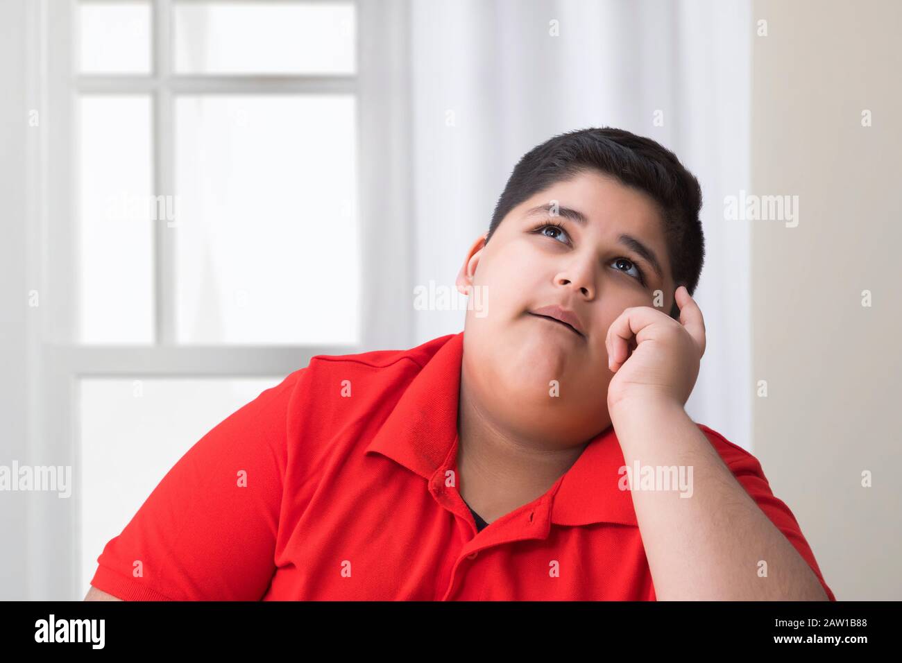 Young boy at home lost in thoughts. (Obesity Stock Photo - Alamy