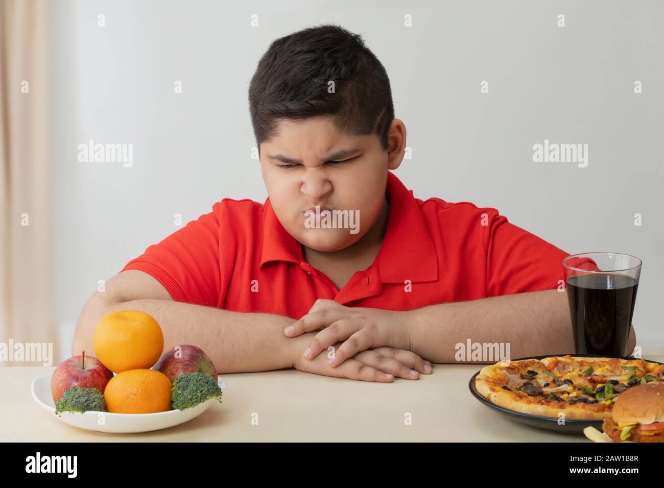Young boy looking angrily at fruits and vegetables. (Obesity Stock ...