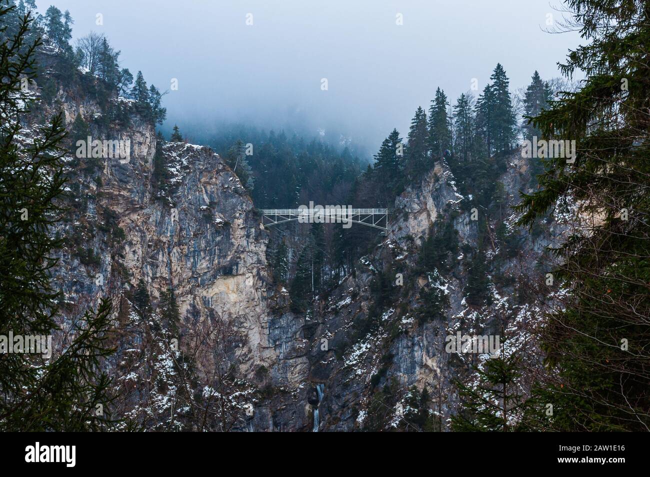 Small bridge between two mountains and a forest covered with fog and ...