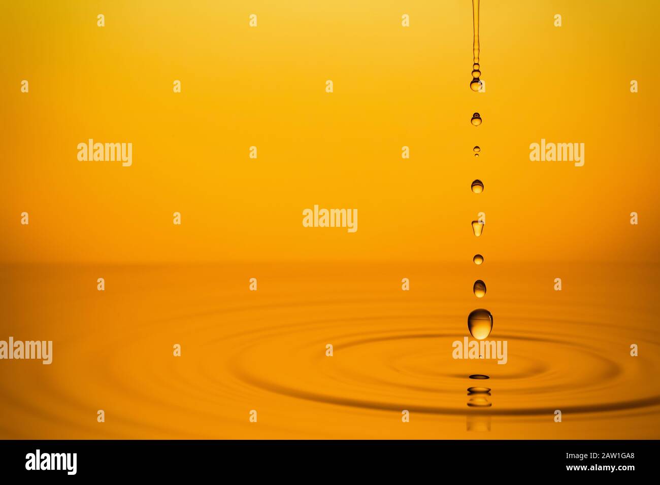 Ripple of the golden surface of yellow liquid with drops Stock Photo ...