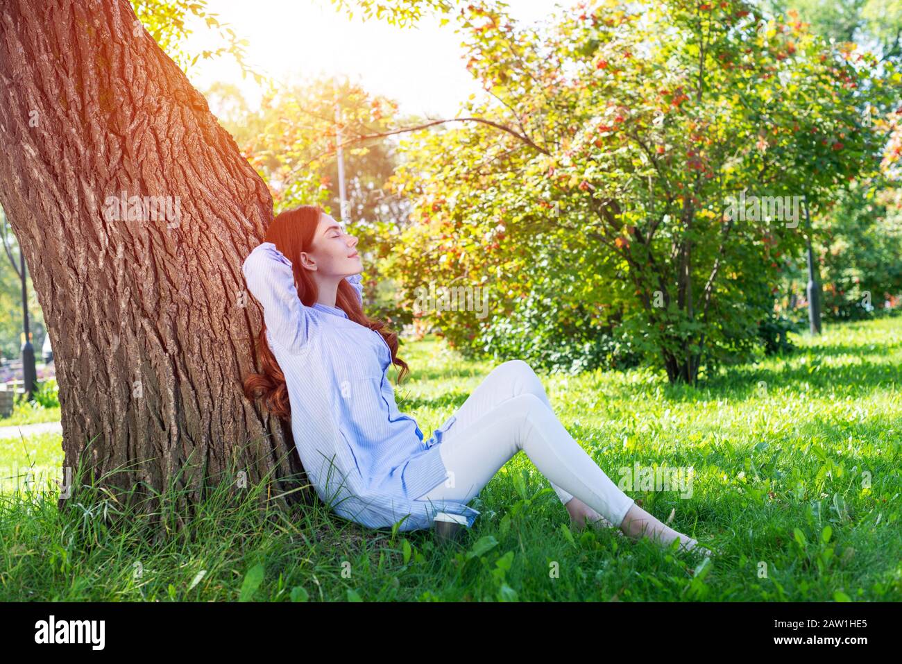 One woman sit against tree hi-res stock photography and images - Alamy