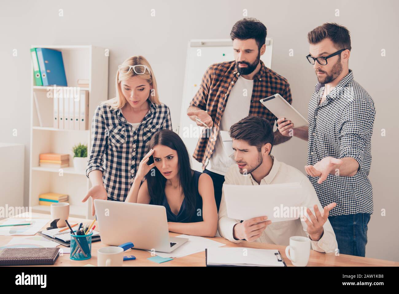 worried and concerned young colleagues at a meeting looking at laptop ...