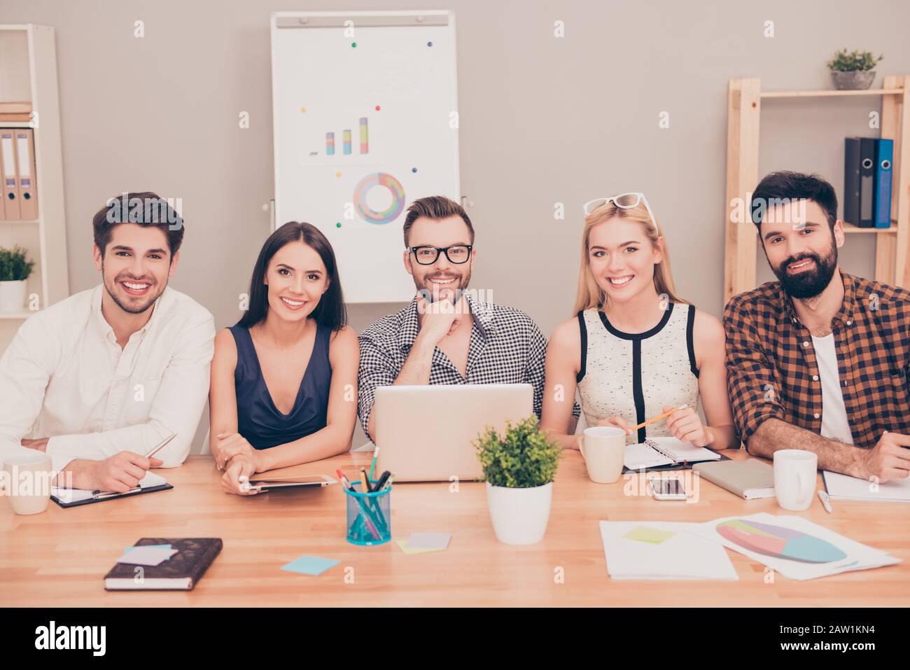photo of happy young team of businesspeople sitting at conference table ...