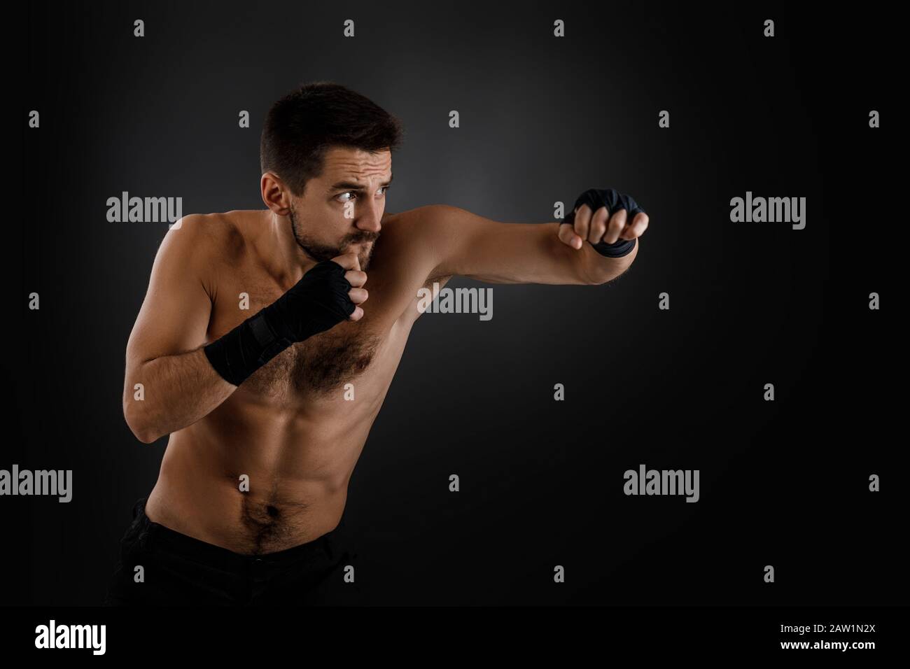 Sportsman boxer throwing a fierce and powerful punch. muscular man on ...