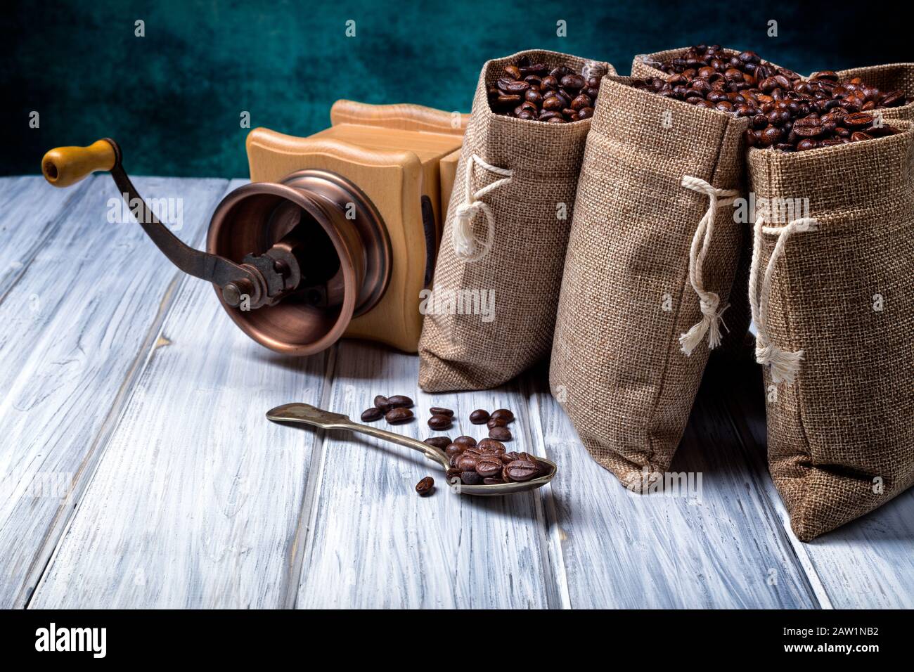 Coffee seeds in spoon with some jute bags filled with coffee and coffee ...