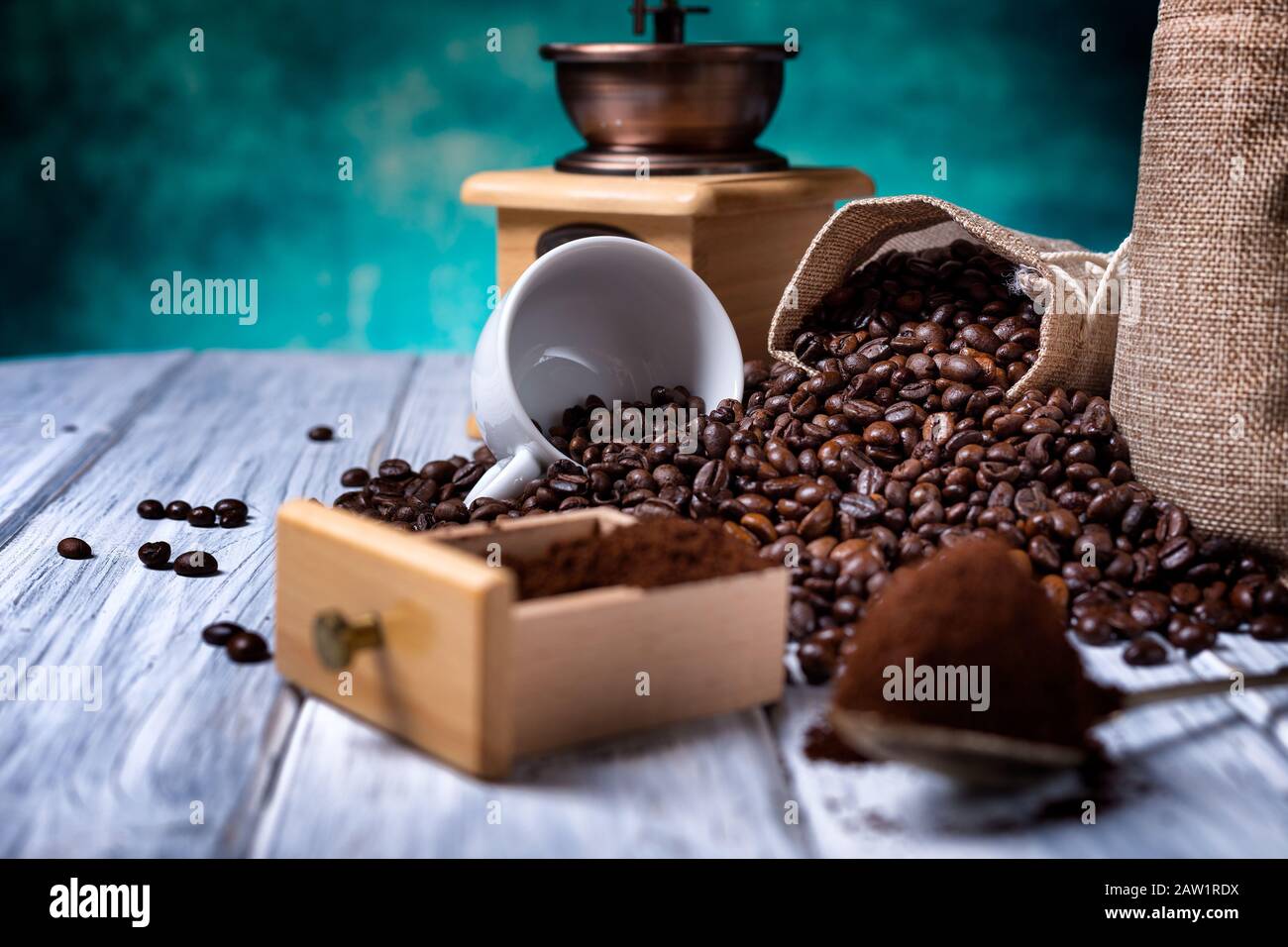 Coffee seeds in spoon with some jute bags filled with coffee and coffee ...