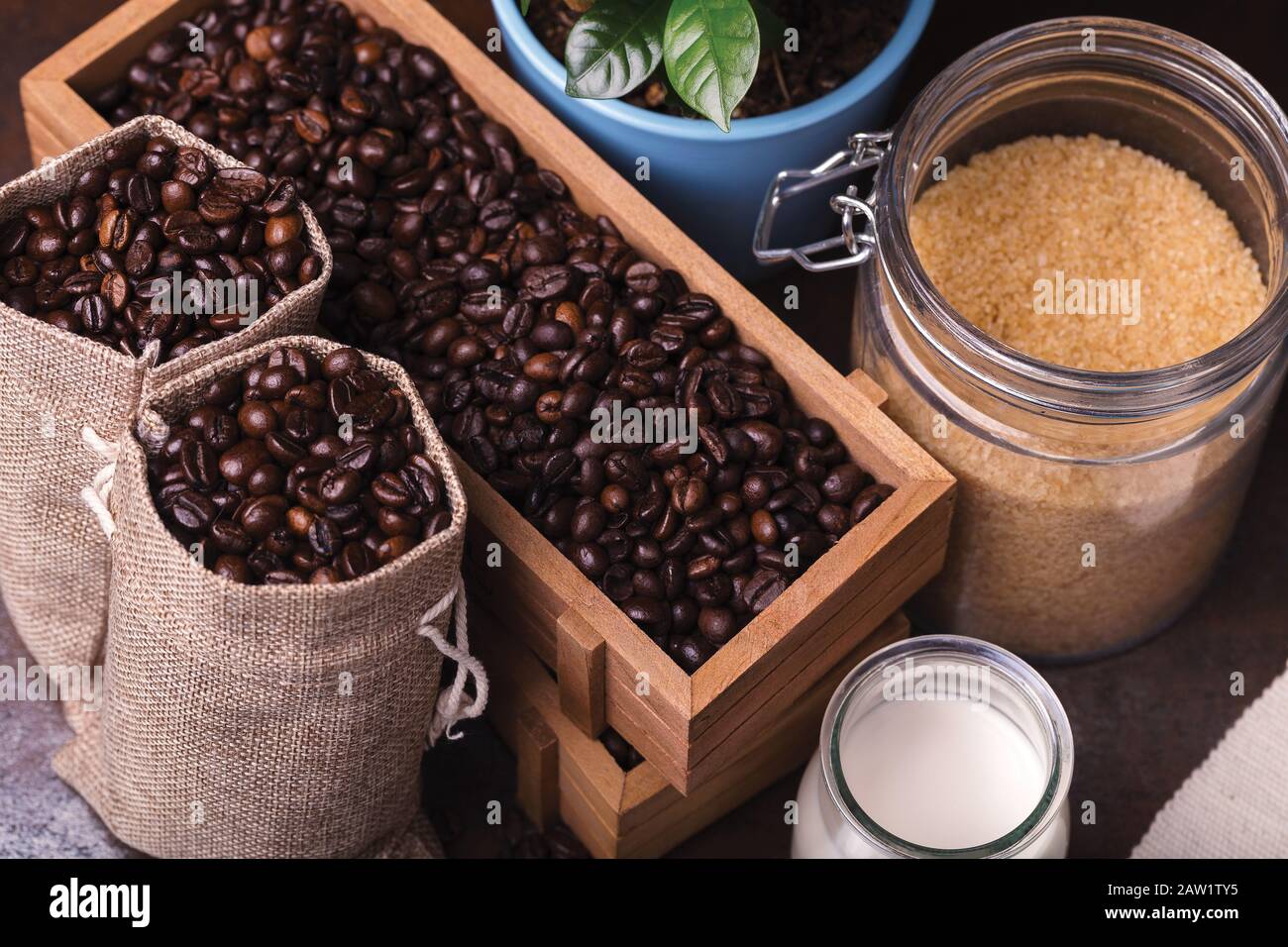 Jute bags, wooden containers filled with coffee beans and glass jar ...