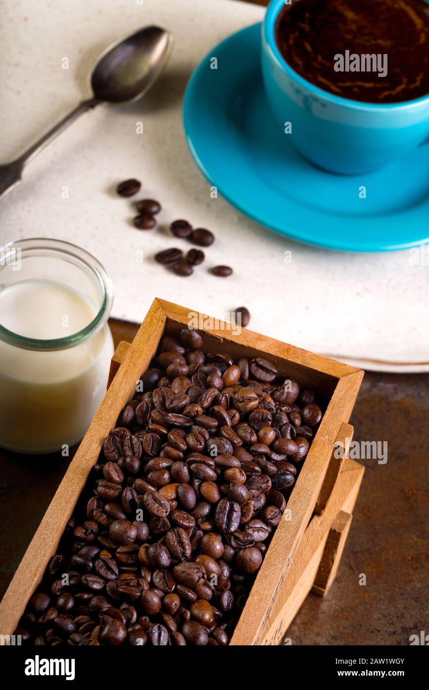 Cup of coffee and wooden containers filled with cofee beans on the rust ...