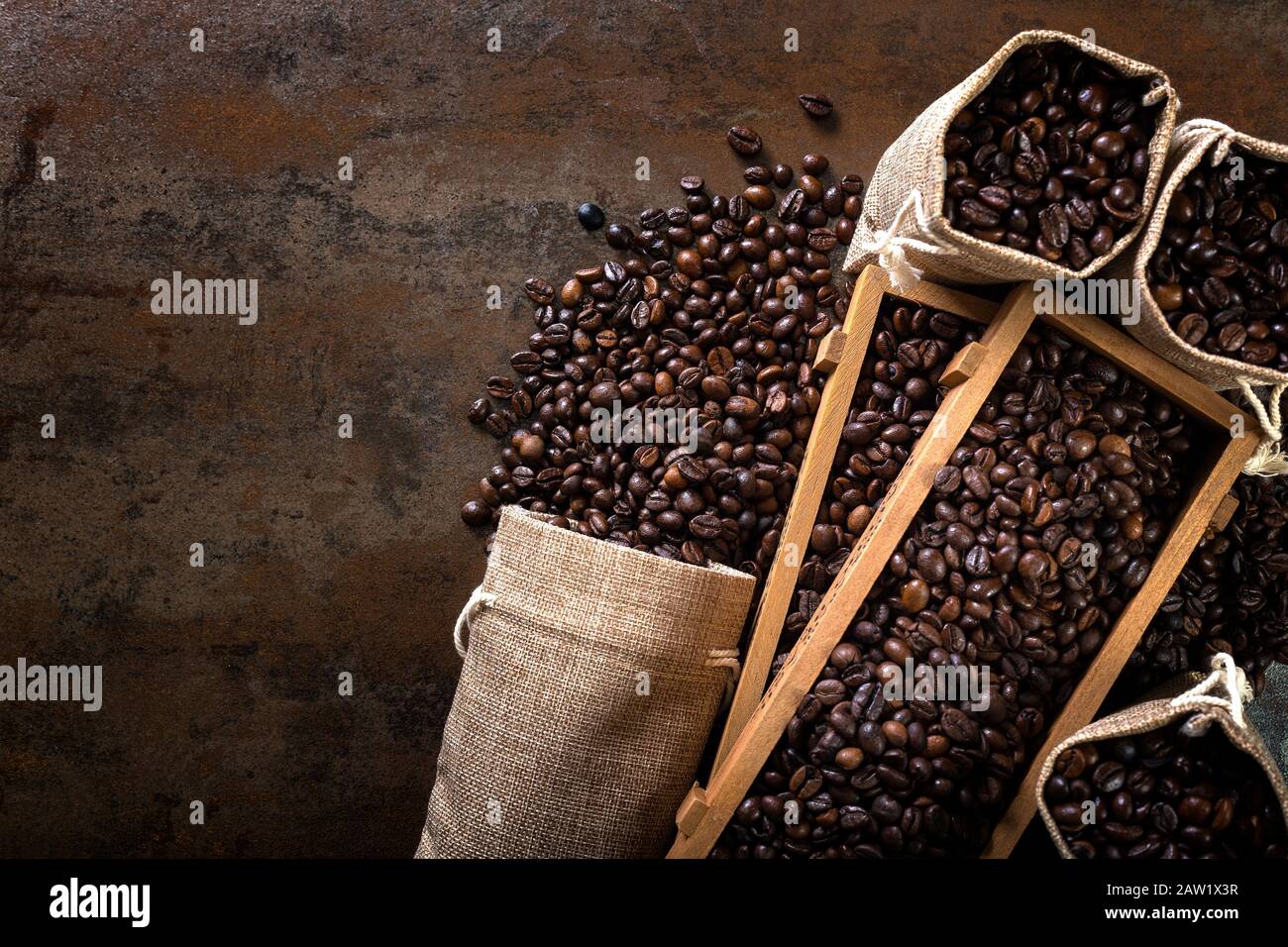 Jute bags and wooden containers filled with cofee beans on the rust ...