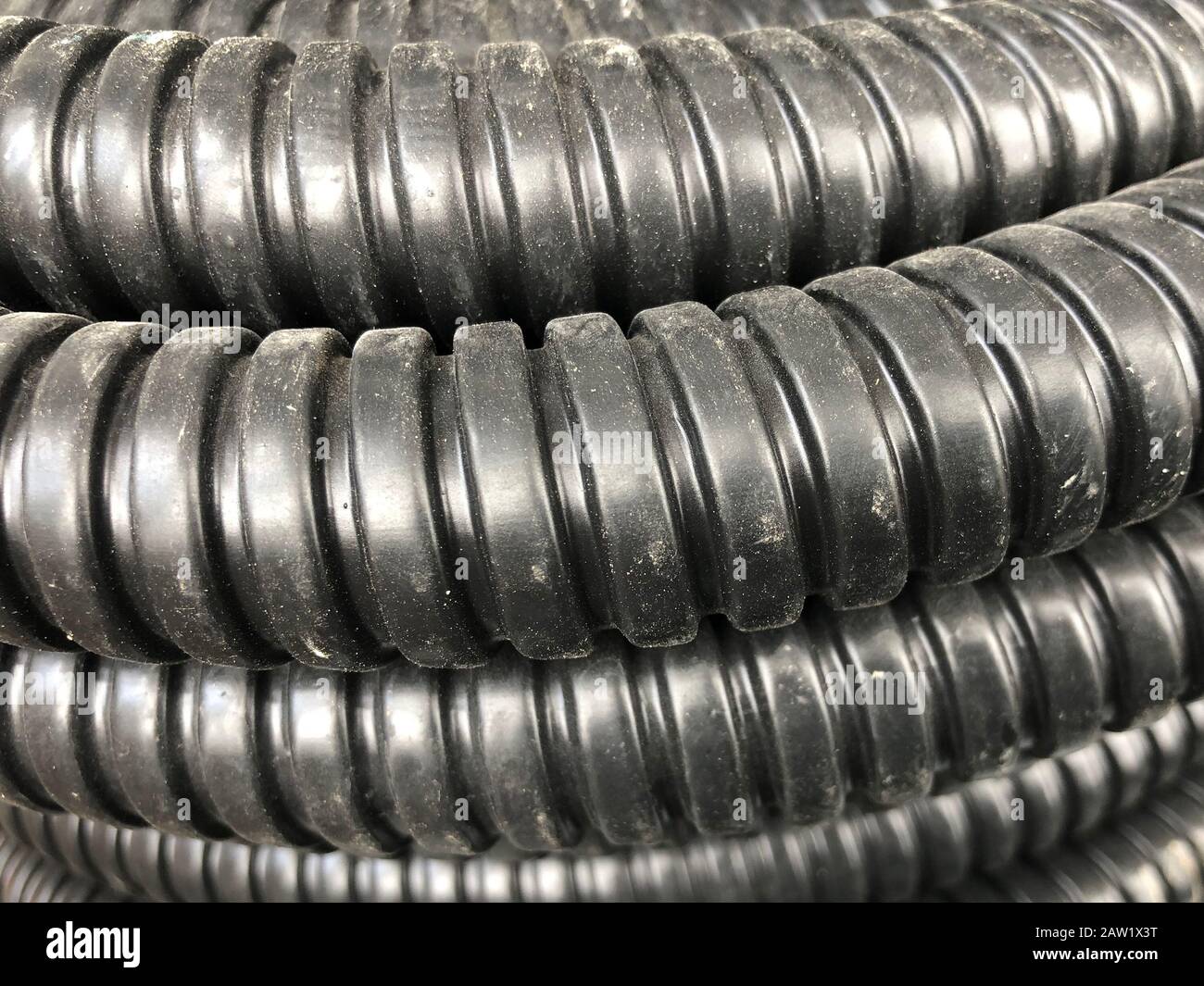 black coiled corrugated insulation tube at warehouse Stock Photo - Alamy