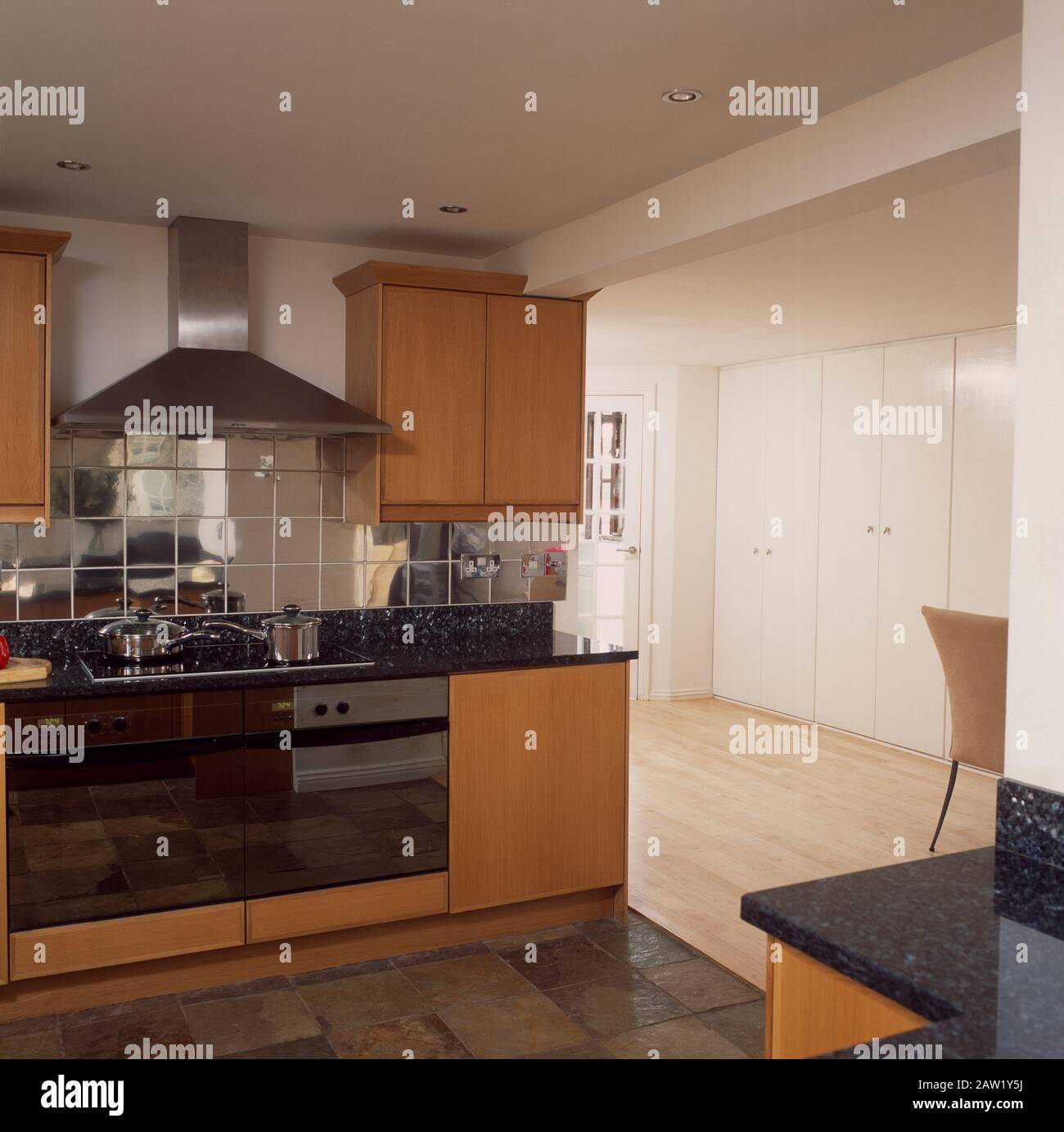 Modern kitchen with mirror tiled splashback Stock Photo - Alamy