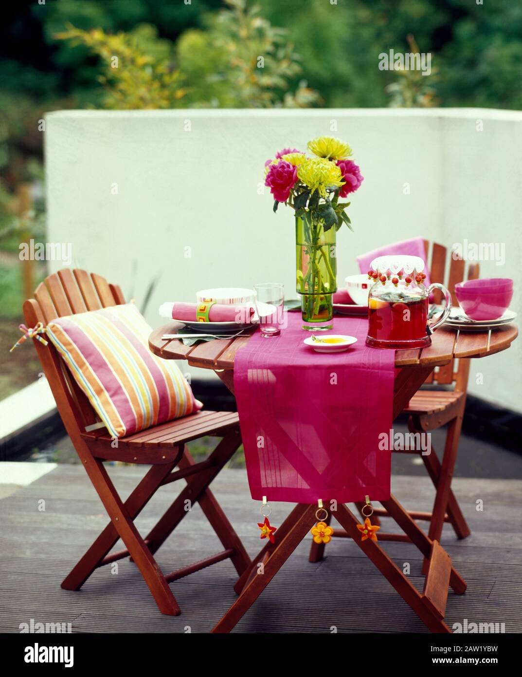 Table set for two outside on decking by pond Stock Photo - Alamy