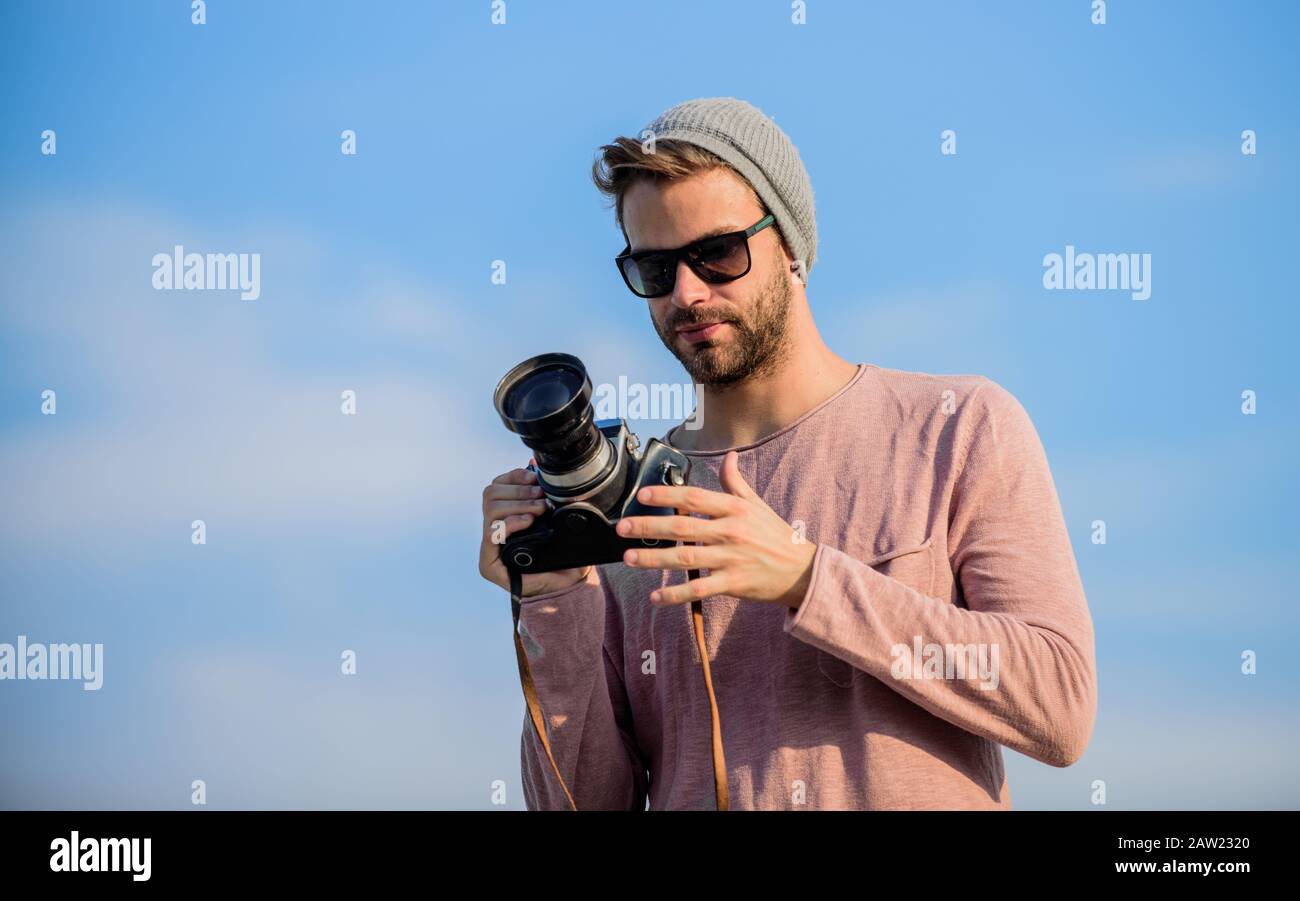 Hipster reporter taking photo. Guy photographer outdoors sky background ...