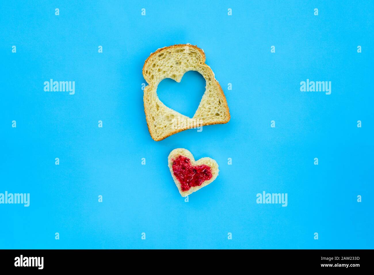 Toast wholegrain bread with heart and jam on light blue background ...
