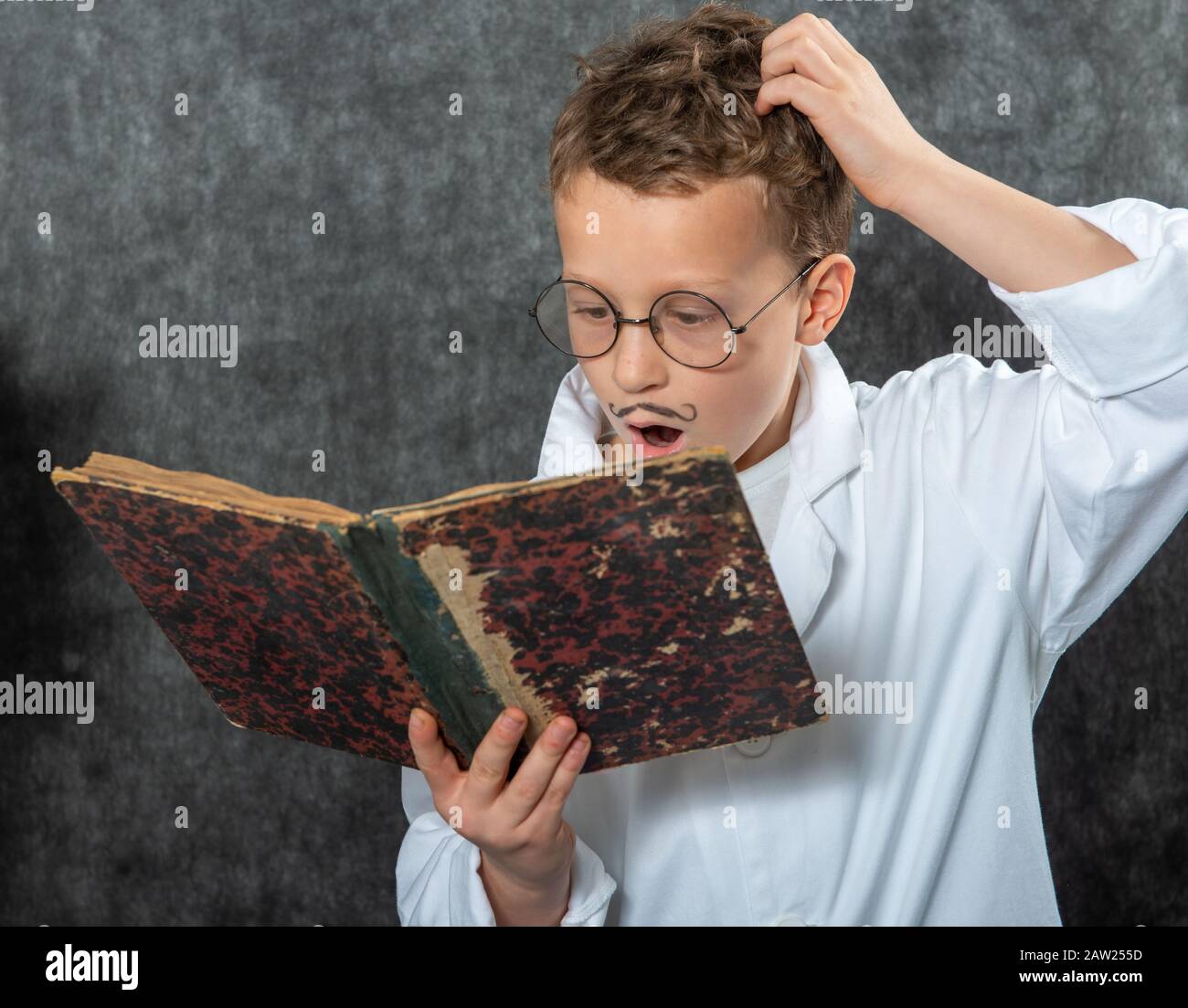 cheerful boy retro with a white blouse reading a old book Stock Photo ...