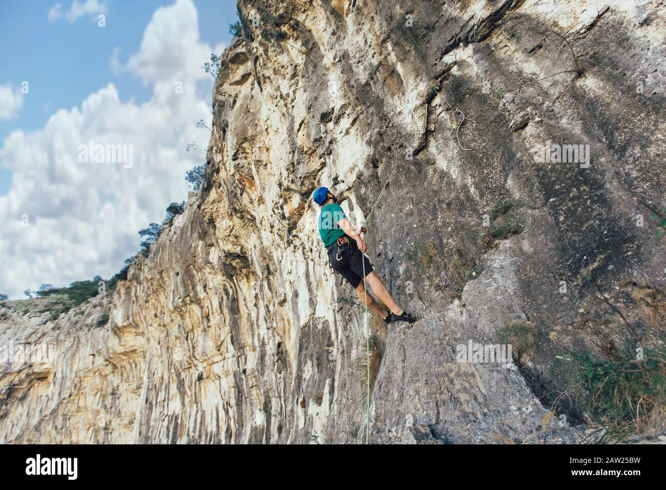 Man with a rope engaged in the sports of rock climbing on the rock Stock Photo - Alamy