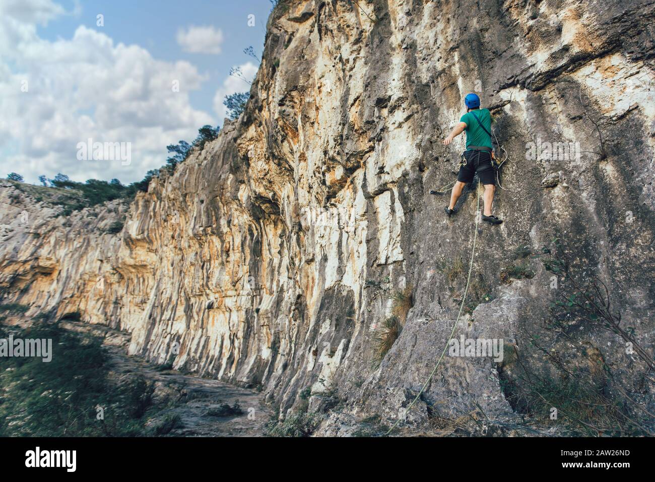 Man with a rope engaged in the sports of rock climbing on the rock Stock Photo - Alamy