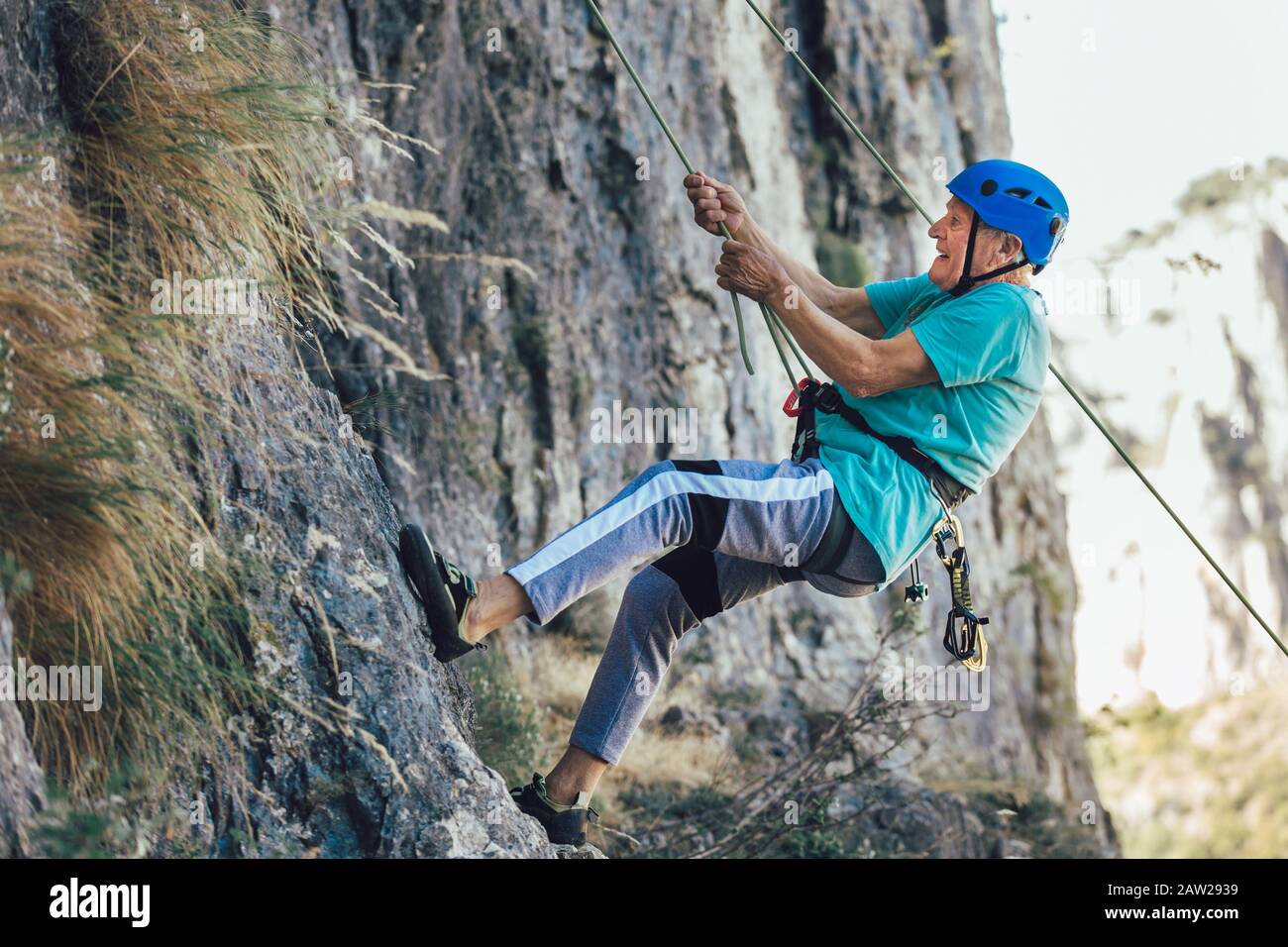 Senior man with a rope climbing on the rock Stock Photo - Alamy