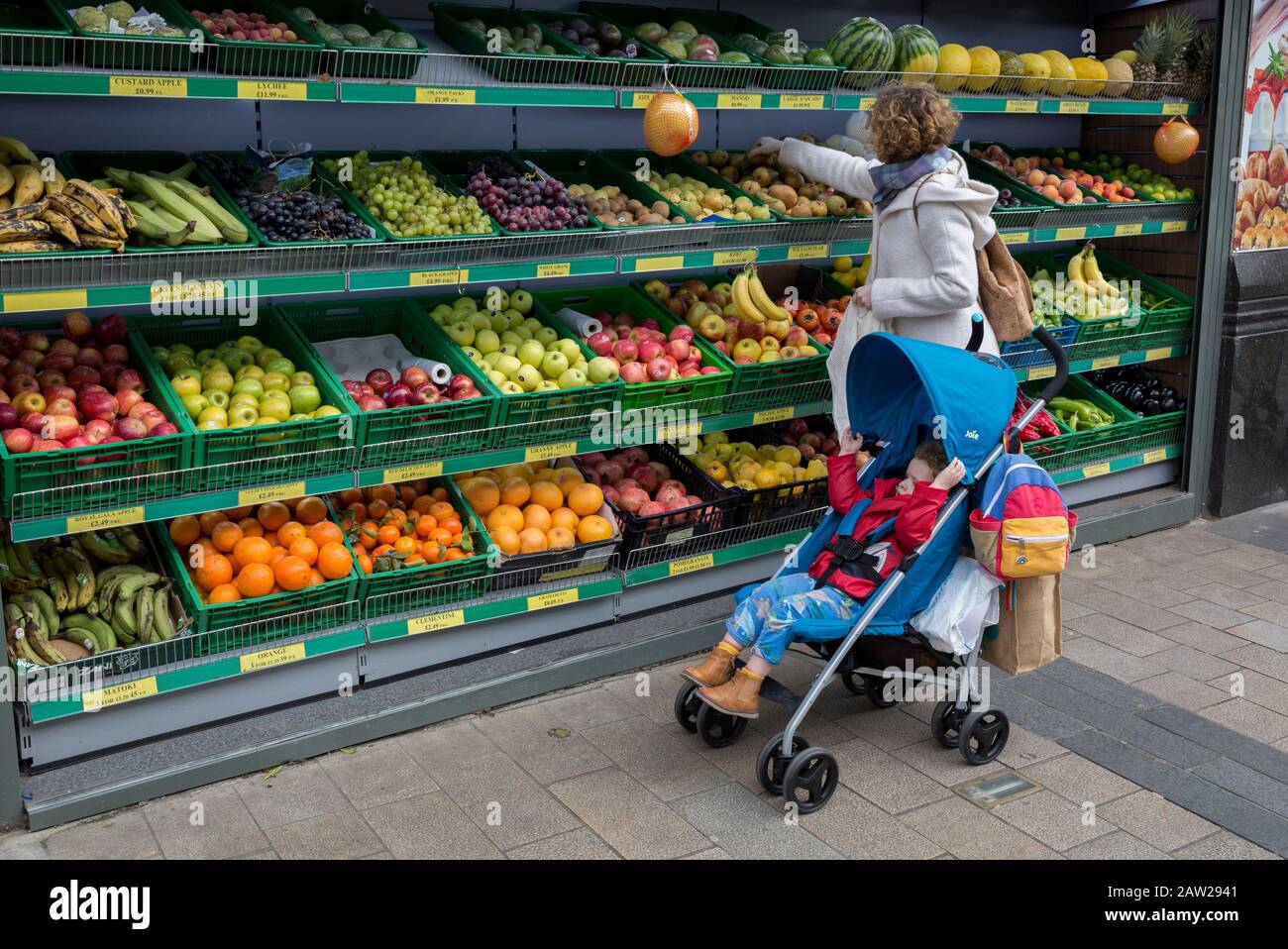 A mother and child stop to choose nutritious fruit and veg from the ...