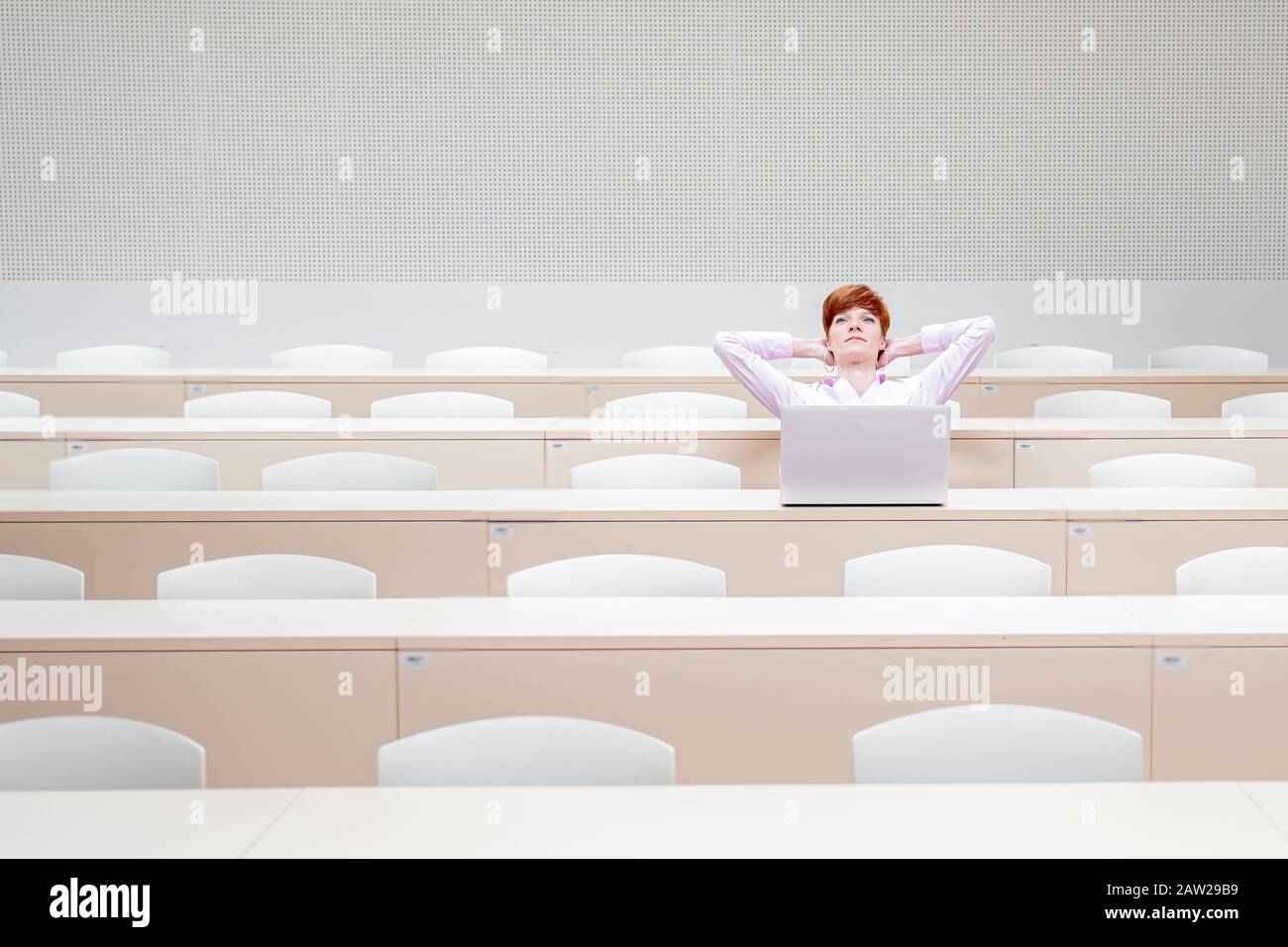 student relaxes in classroom after successfully completing college ...