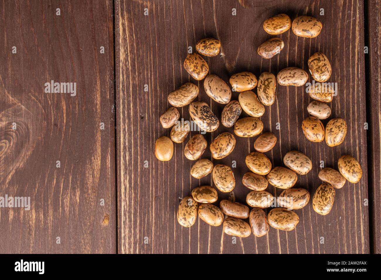Lot of whole mottled brown bean pinto flatlay on brown wood Stock Photo ...