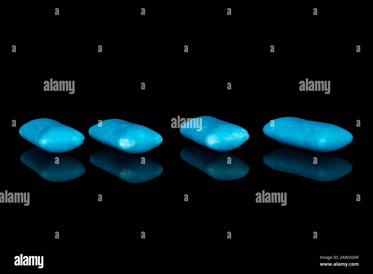 Group of four whole blue chewing gum isolated on black glass Stock ...