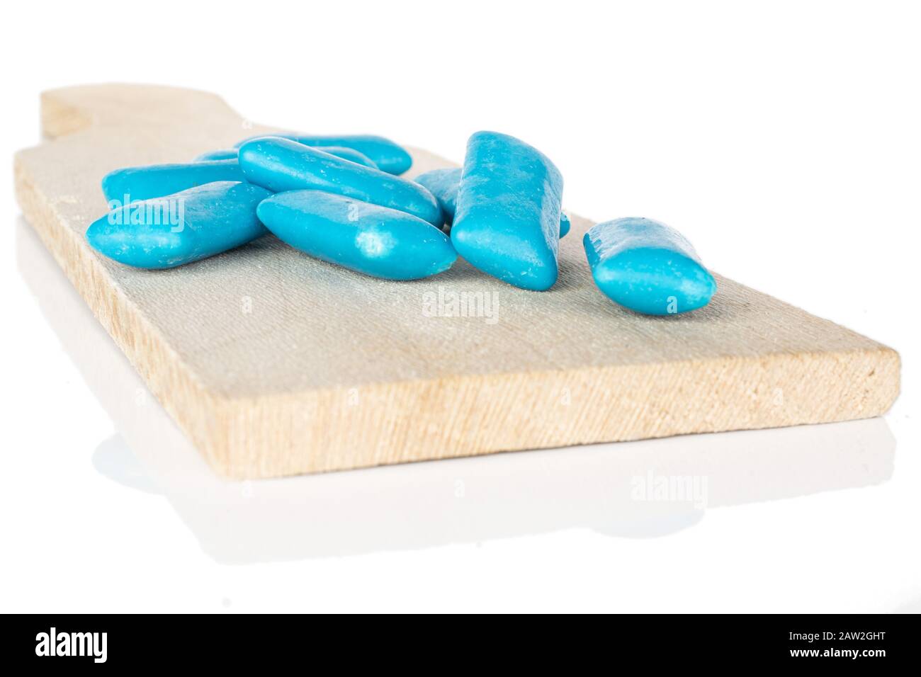 Group of eight whole blue chewing gum on wooden cutting board isolated ...