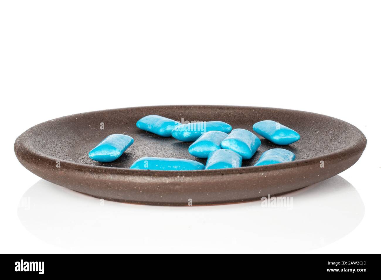 Lot of whole blue chewing gum with brown ceramic coaster isolated on ...