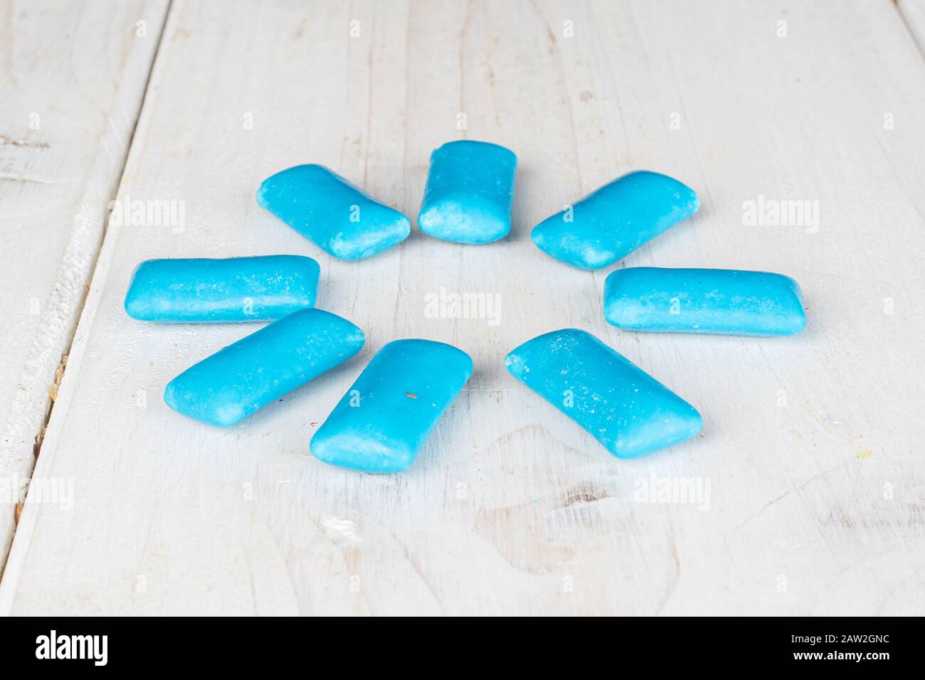 Group of eight whole blue chewing gum on white wood Stock Photo - Alamy