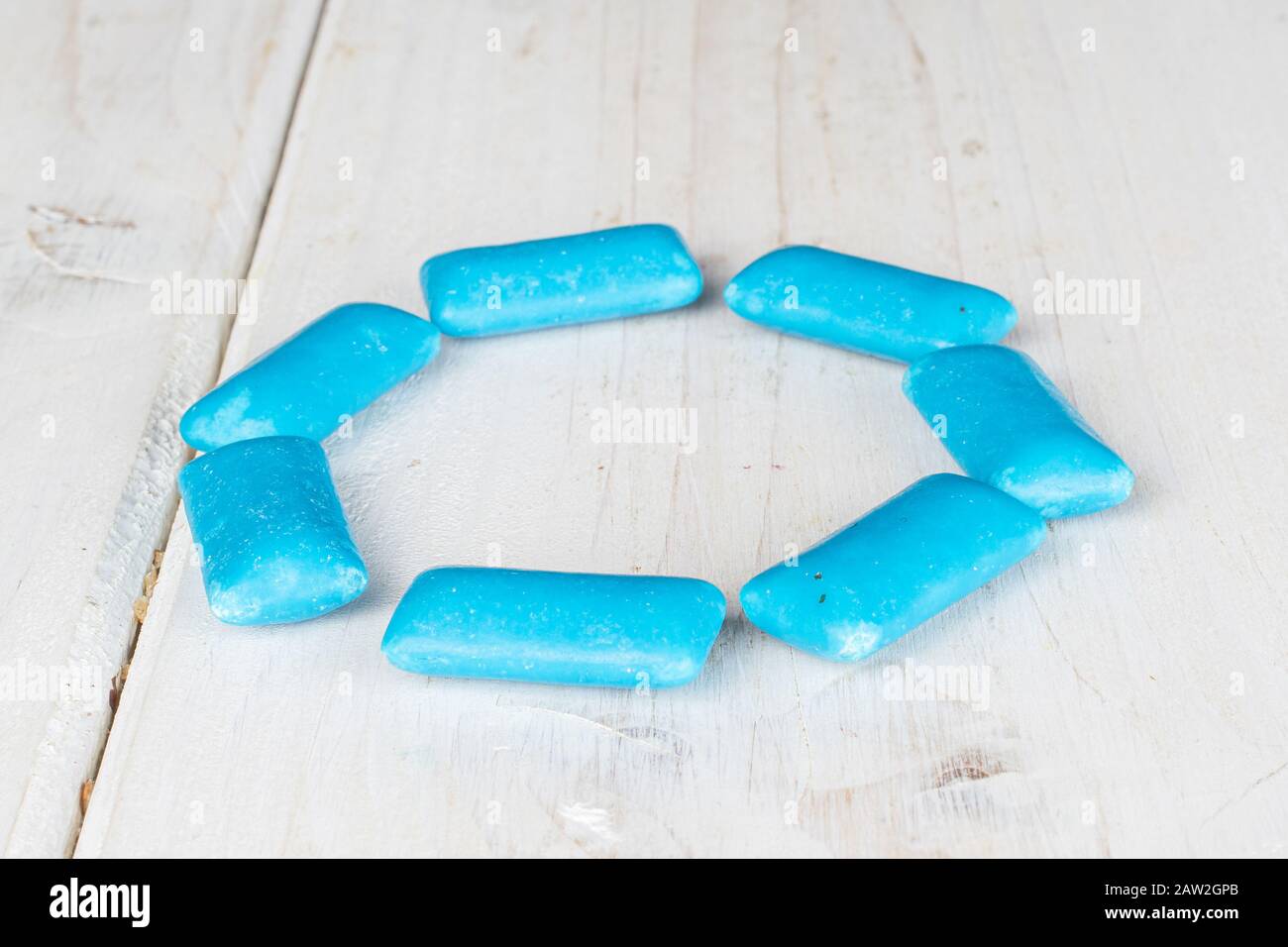Group of seven whole blue chewing gum on white wood Stock Photo - Alamy