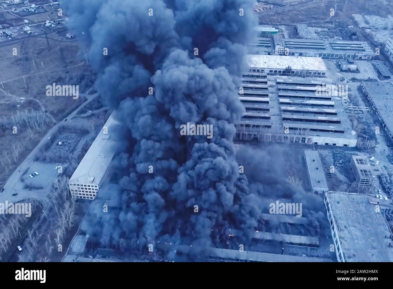 A major fire at the factory. dark puffs of smoke from buildings Stock ...