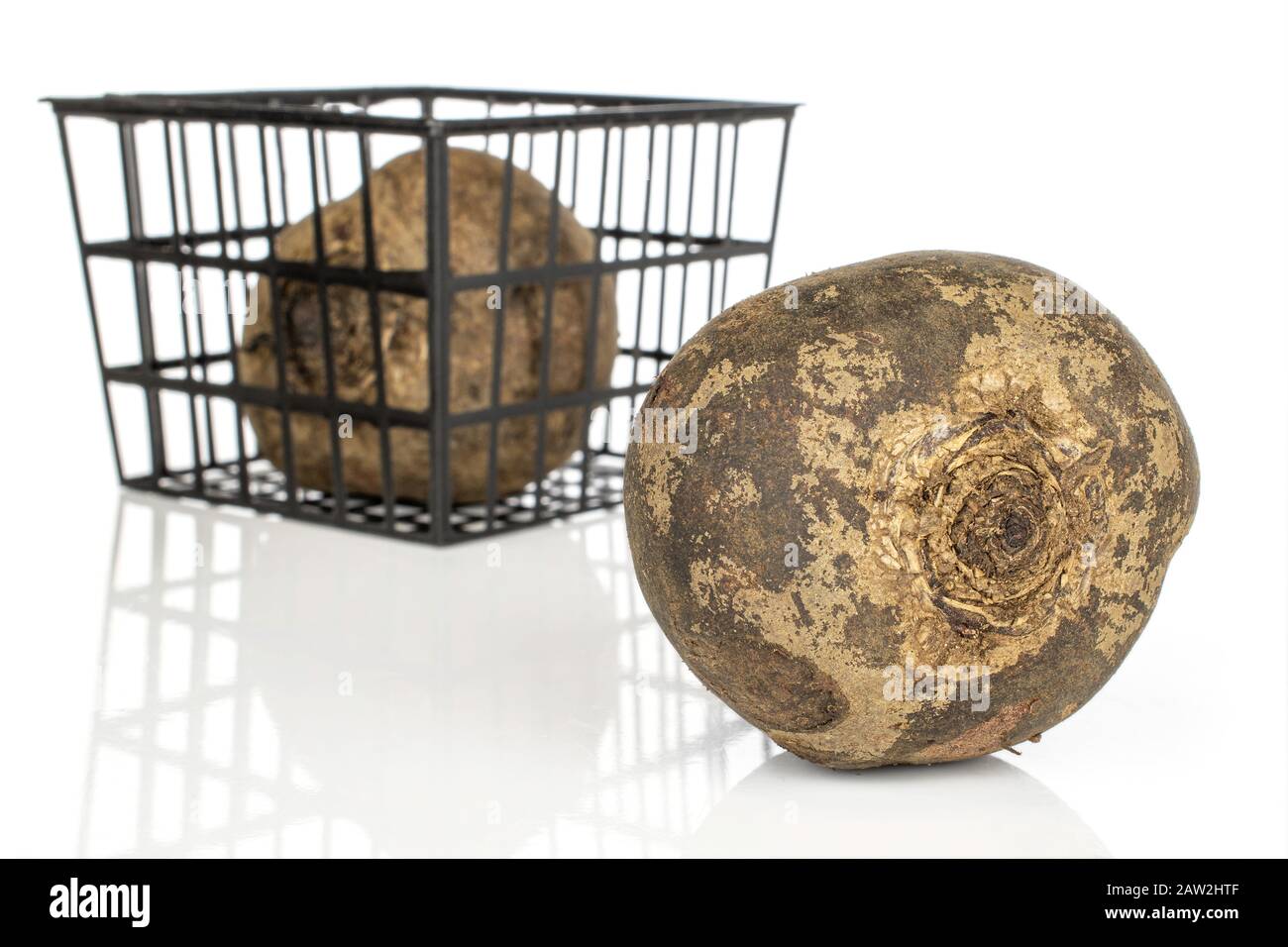 Group of two whole raw sweet beetroot in black plastic basket isolated ...