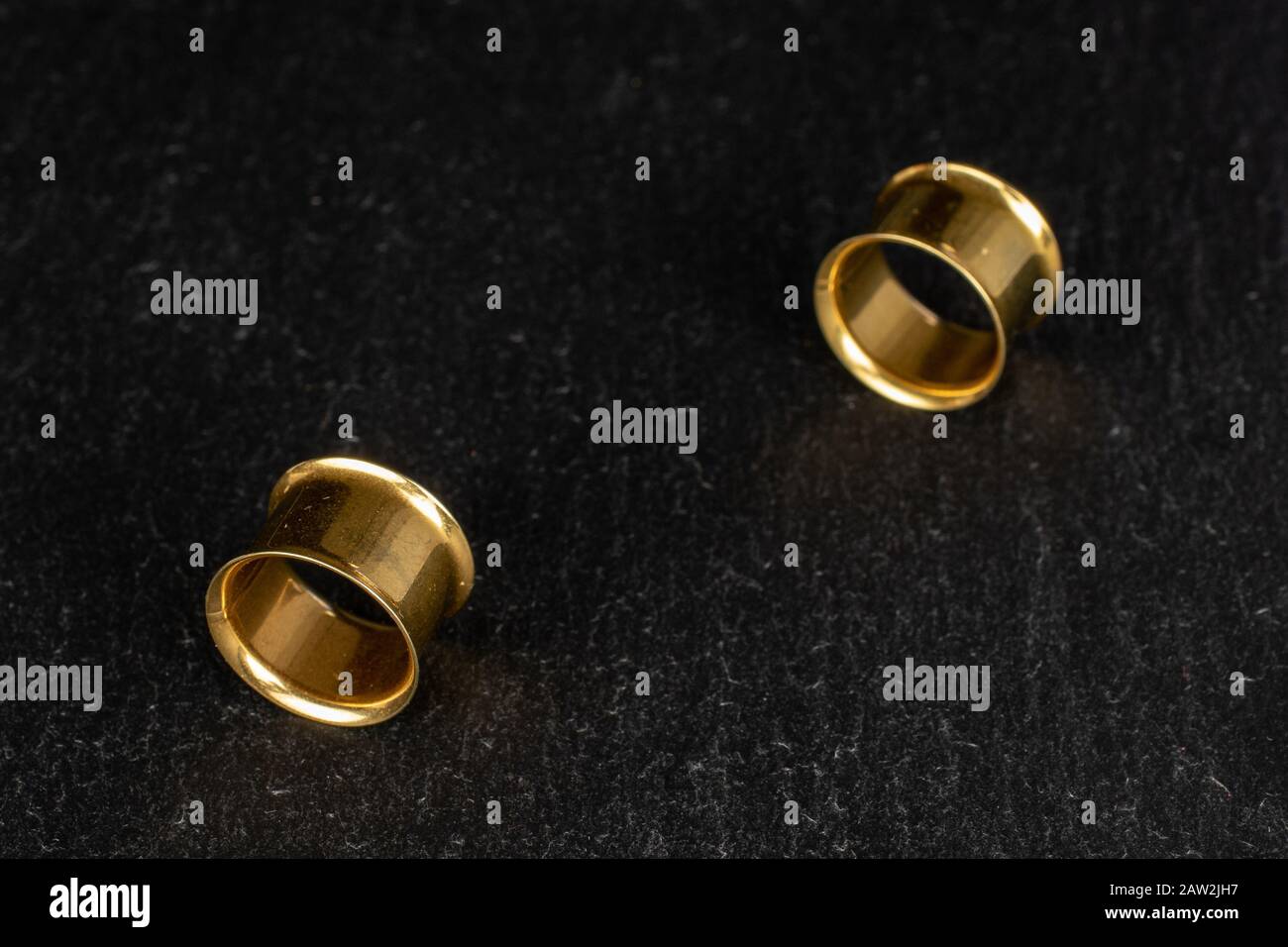 Group of two whole golden plug on grey stone Stock Photo - Alamy