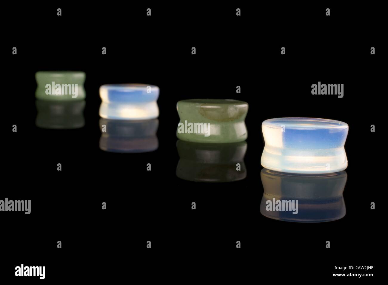 Group of four whole plug diagonal isolated on black glass Stock Photo ...